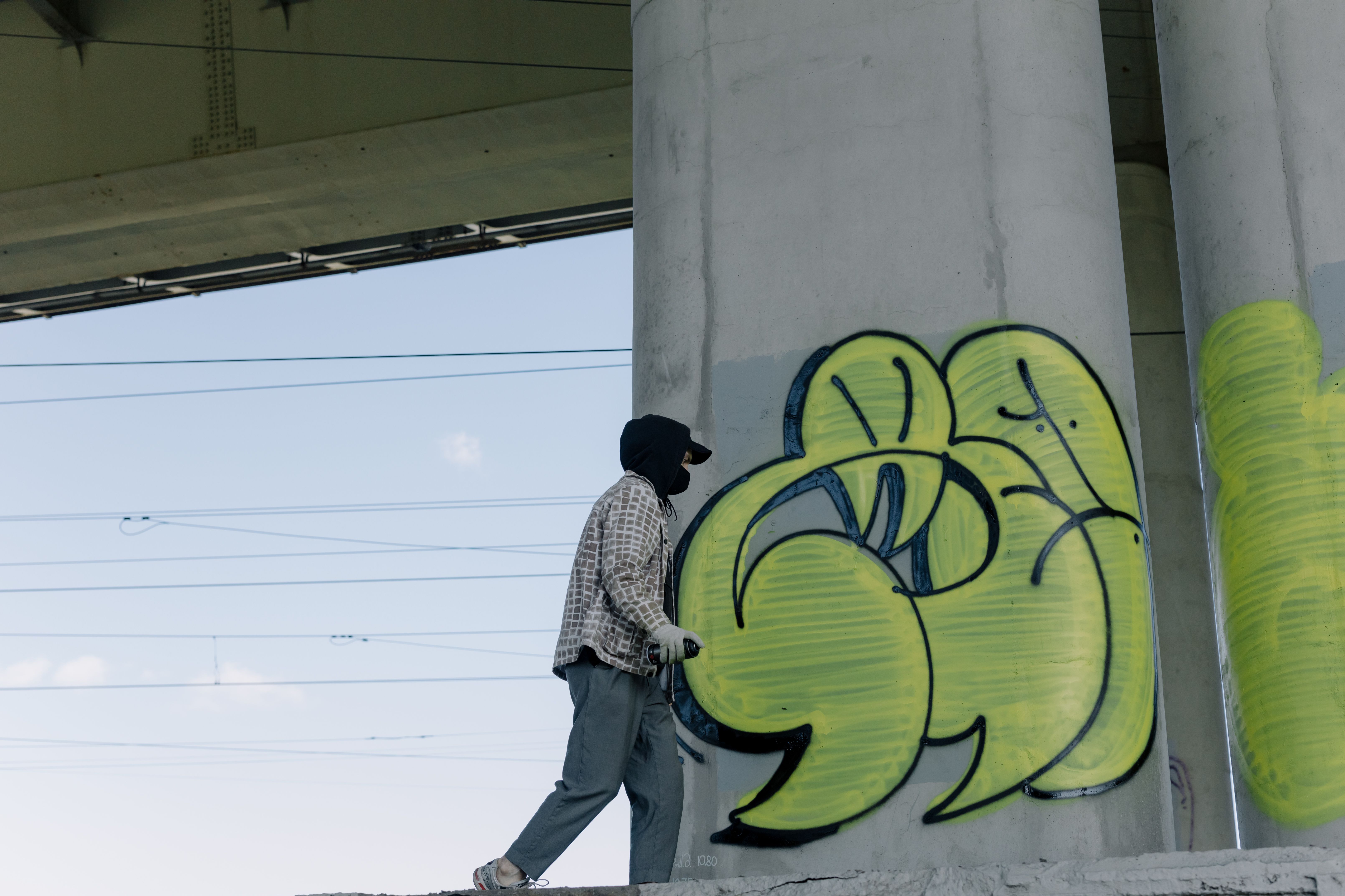 A Person Spray Painting under the Bridge · Free Stock Photo