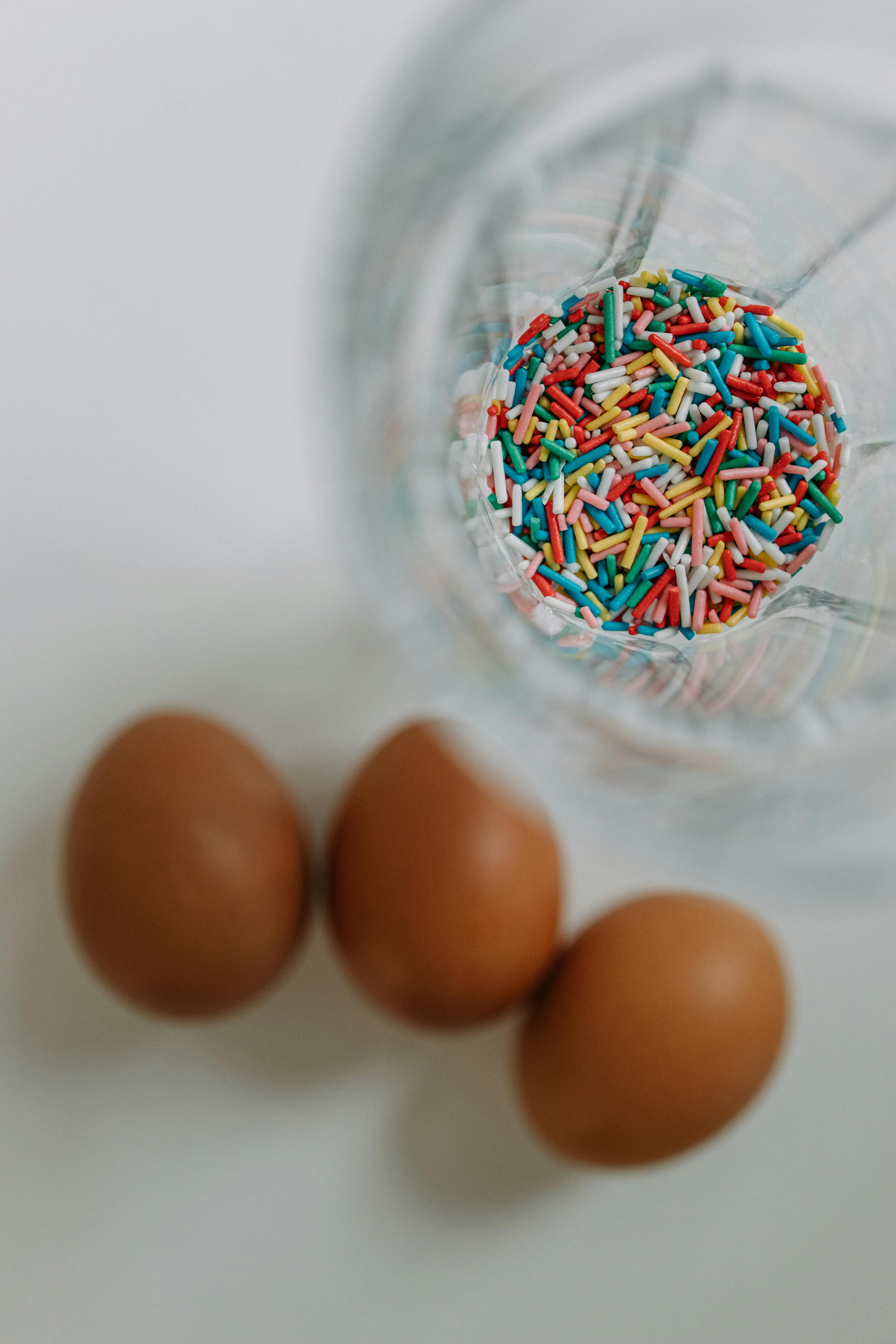 Close-Up Shot of Sprinkles in a Glass beside Eggs · Free Stock Photo