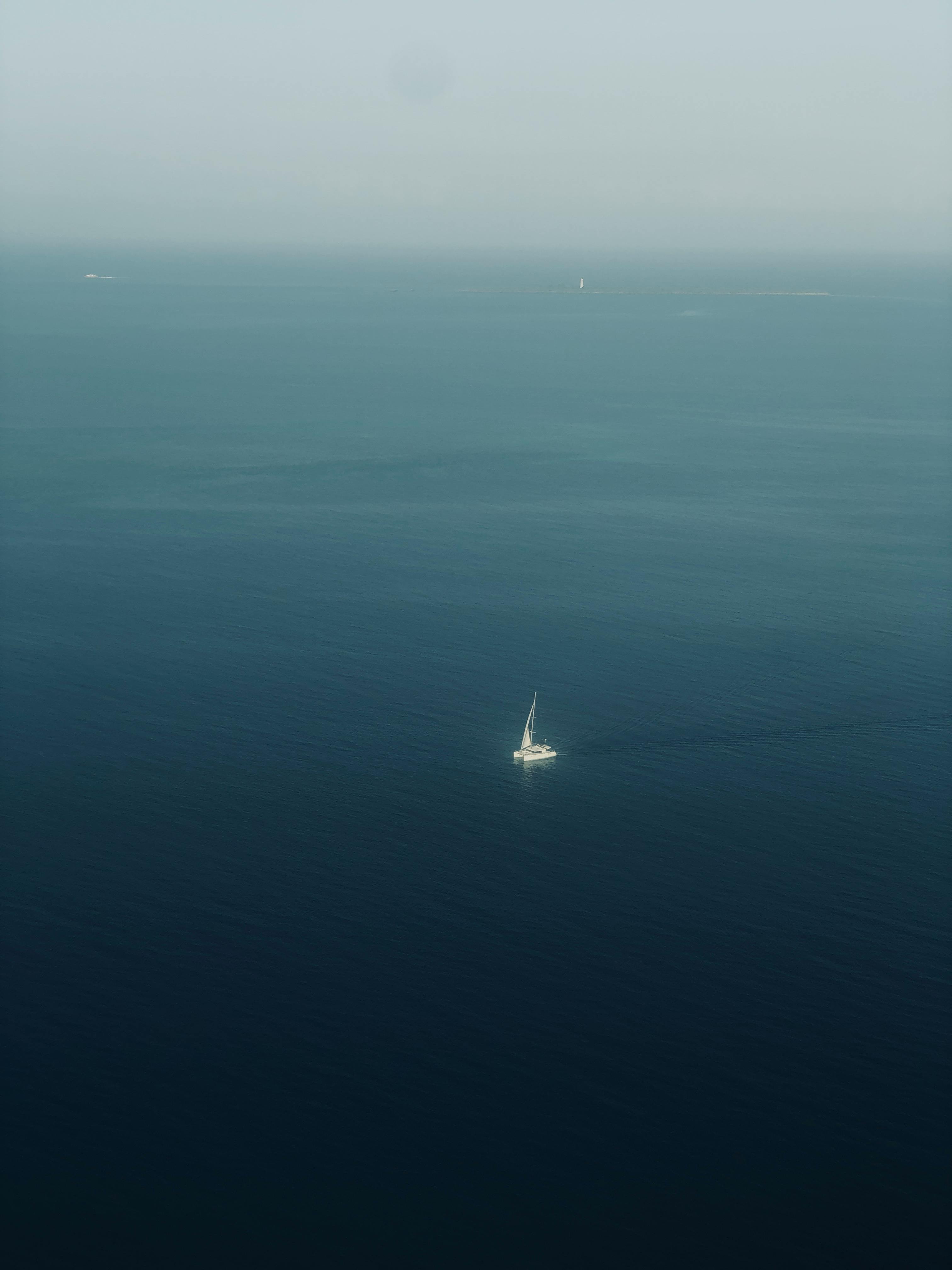 Road with vehicles over sea near moored boats · Free Stock Photo