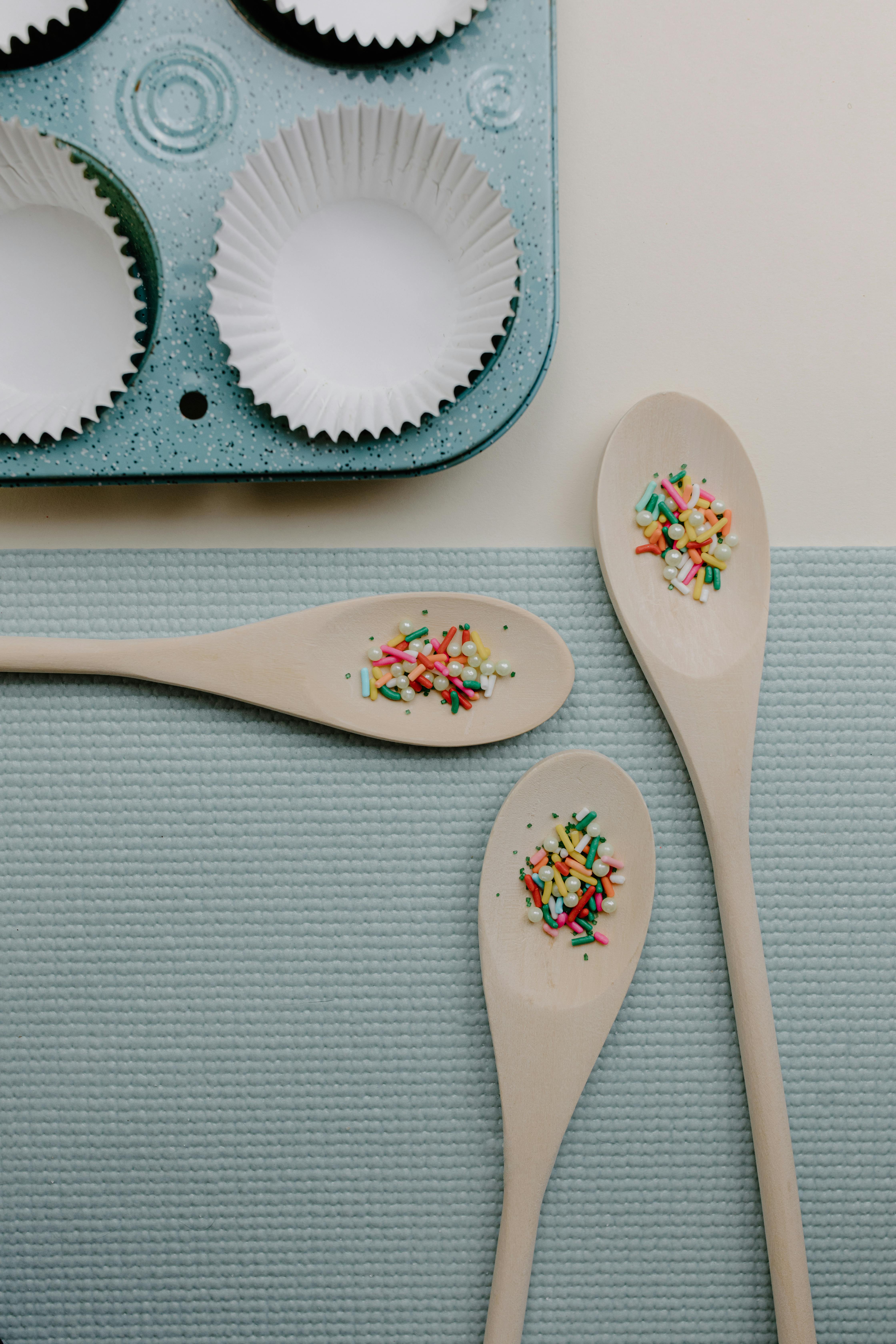 Sprinkles on Wooden Spoons and Cupcake Tins · Free Stock Photo