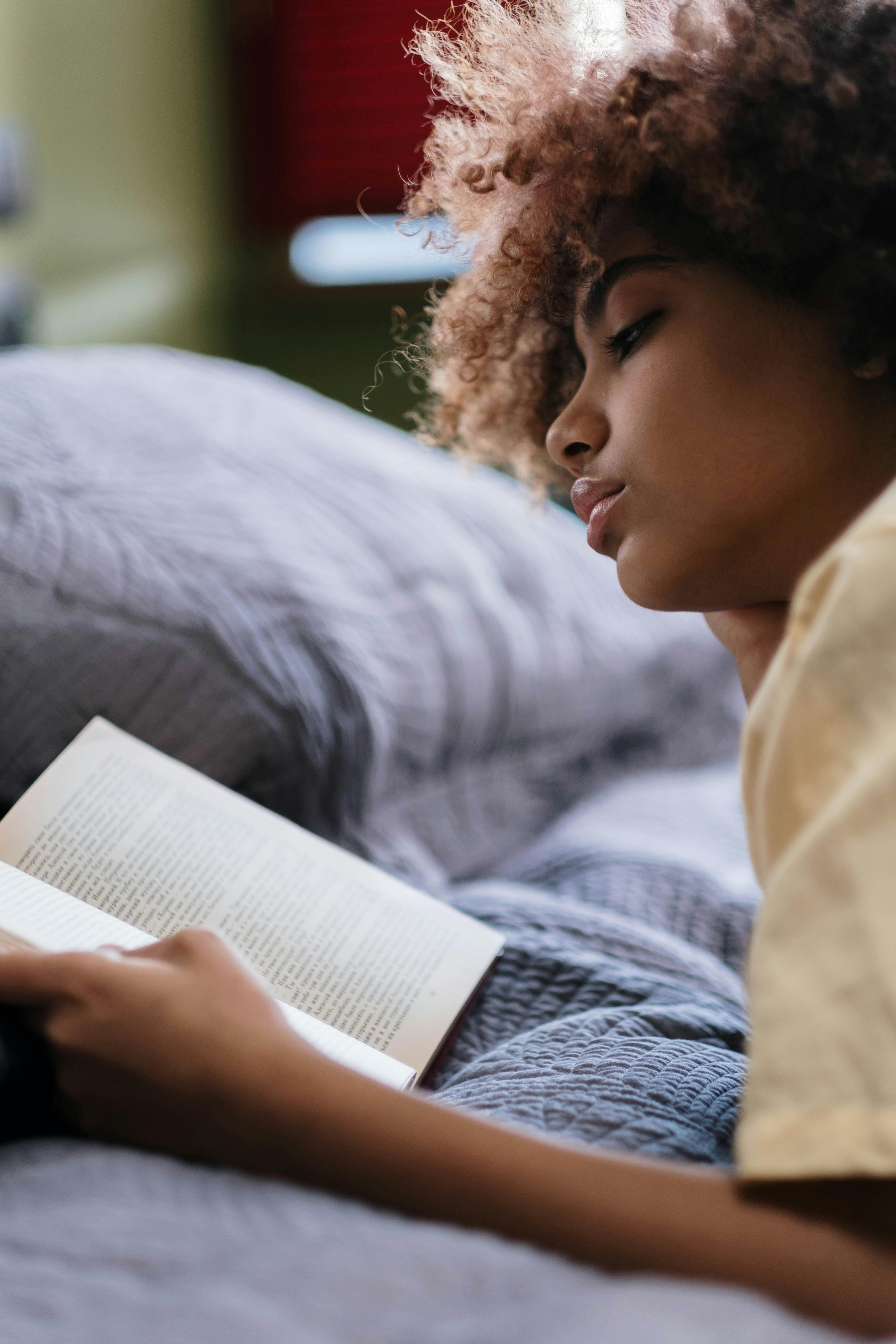 A Woman with Curly Hair Reading a Magazine · Free Stock Photo