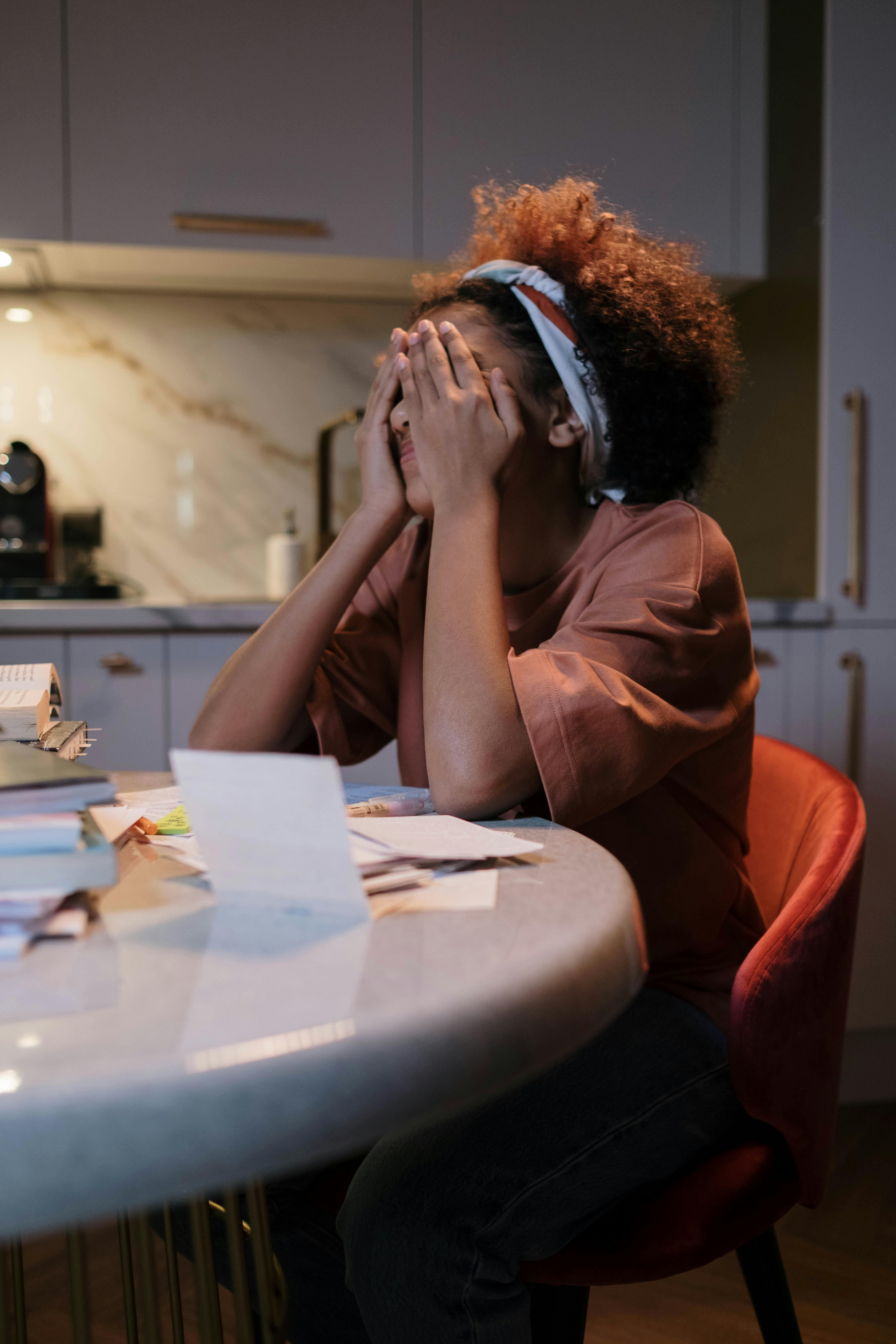 Tired Woman Sitting by Table in Kitchen · Free Stock Photo