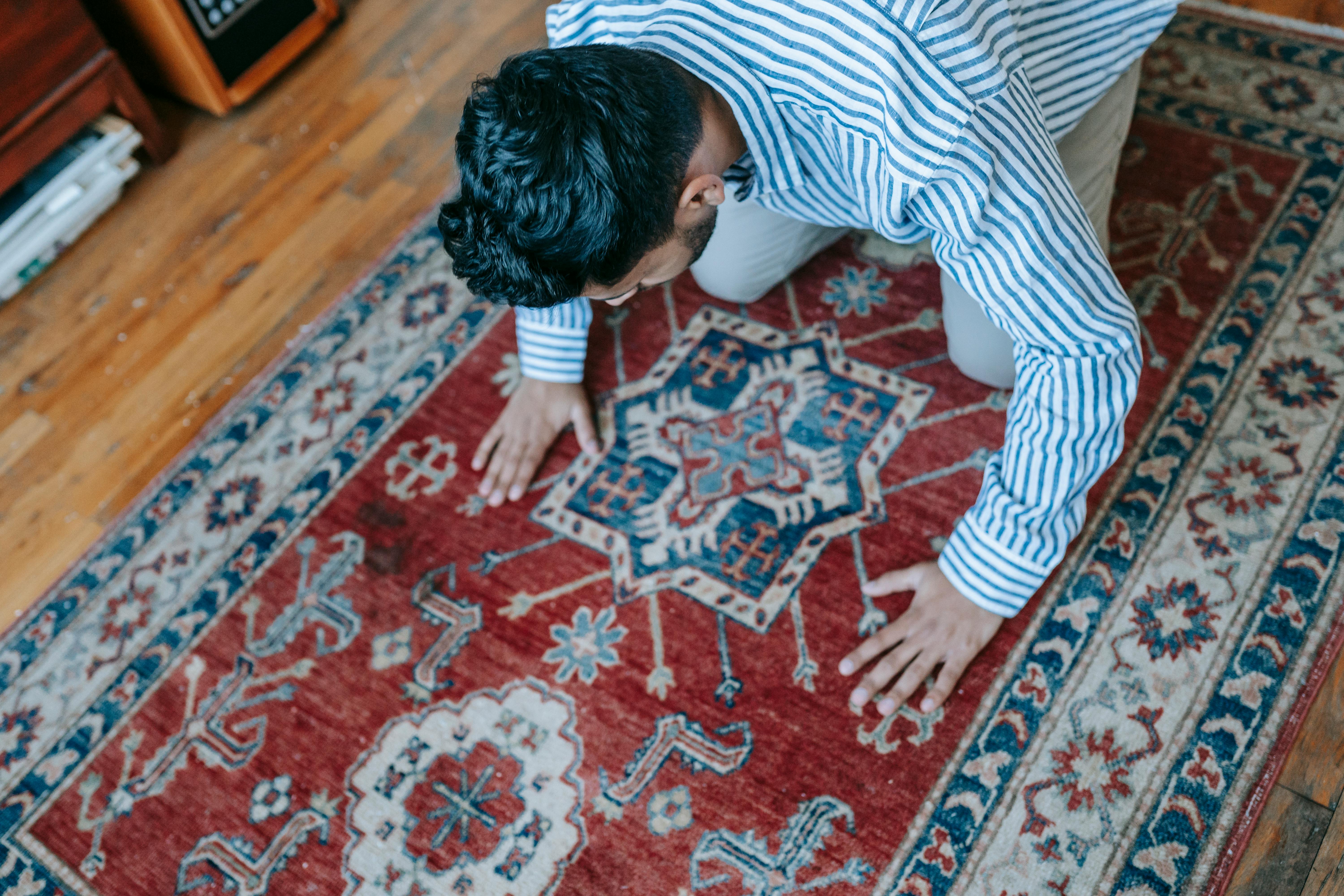 Man Kneeling on The Rug · Free Stock Photo