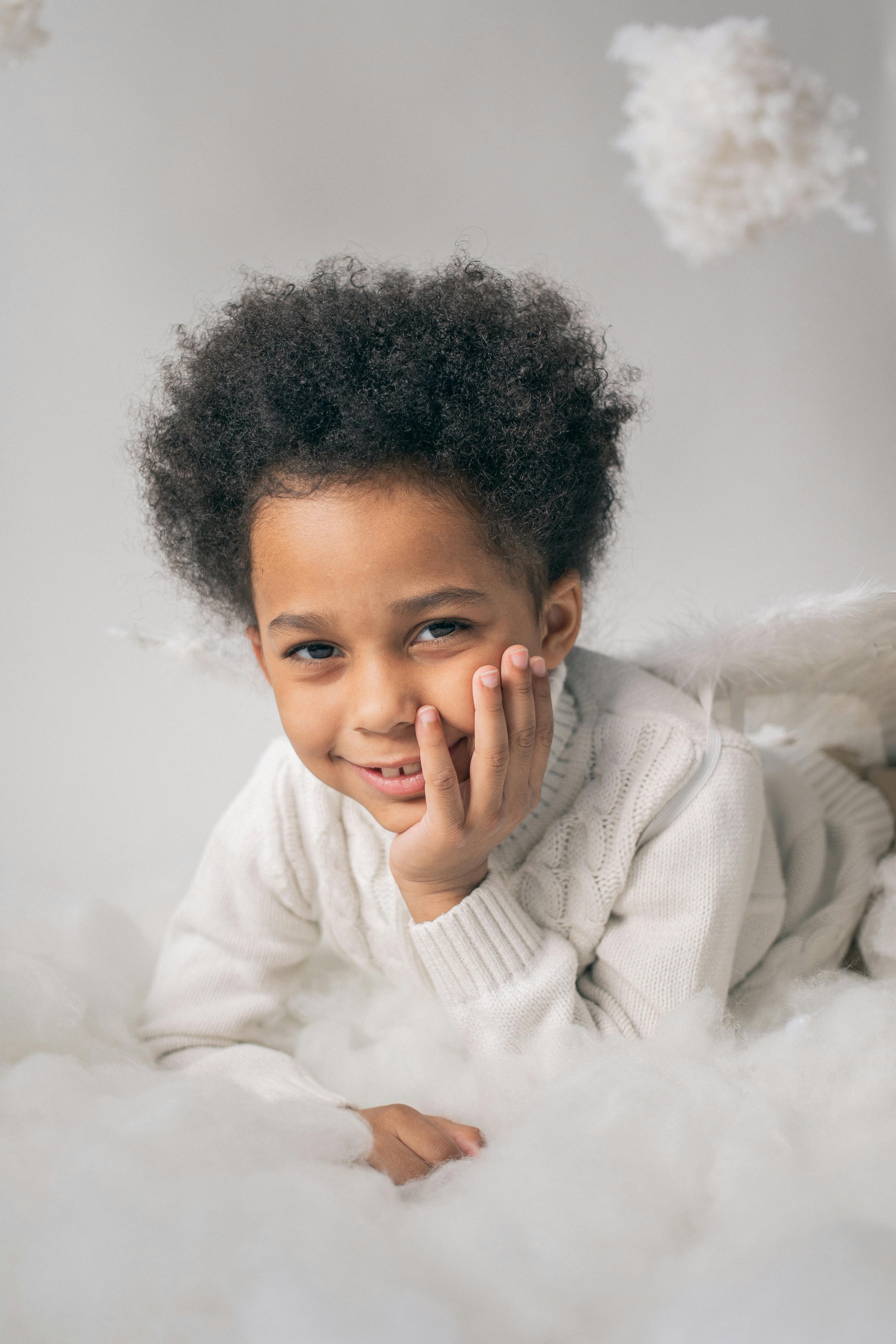 Cute black boy lying on cotton wool · Free Stock Photo