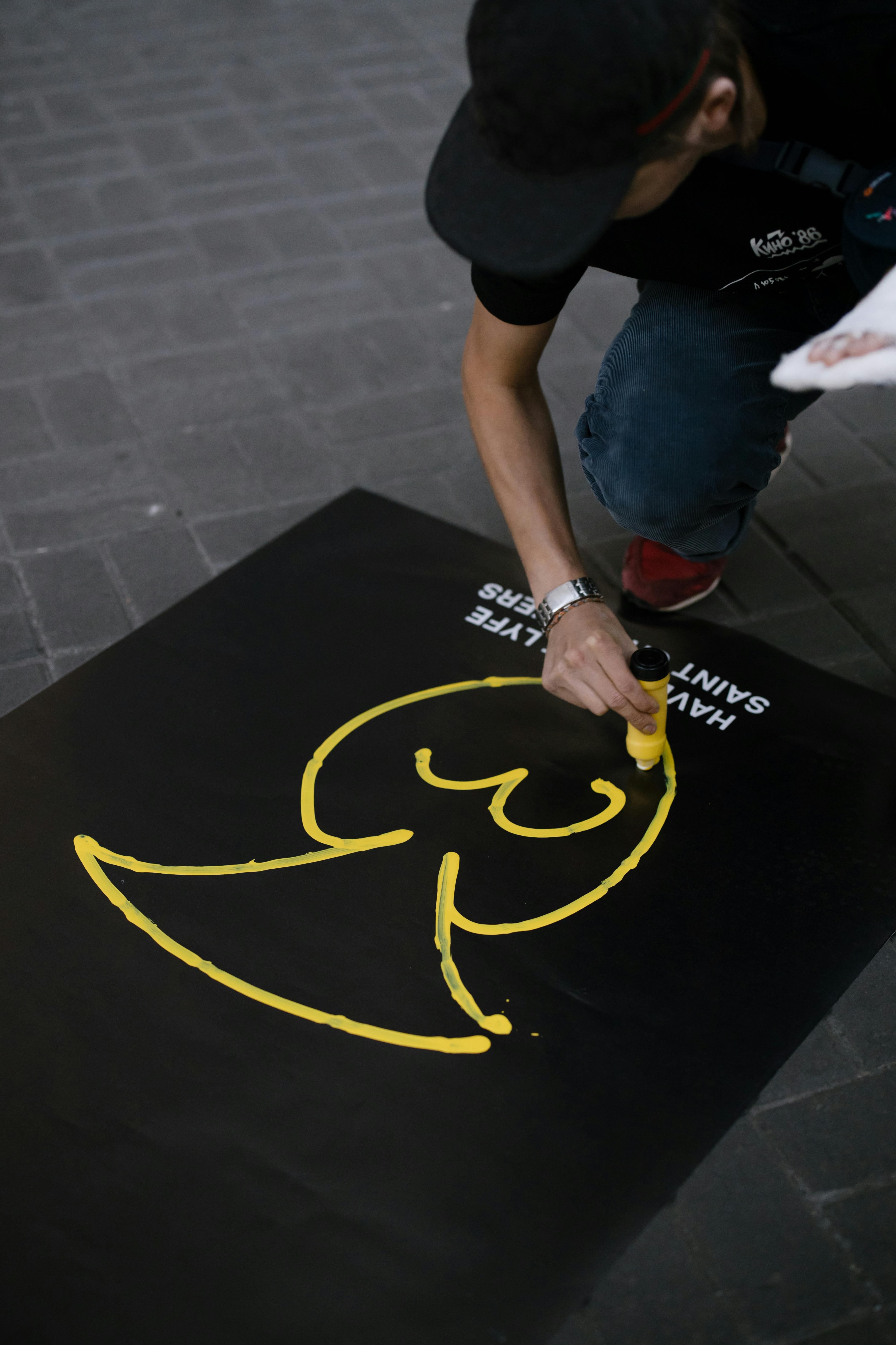 Man Drawing a Poster on the Sidewalk · Free Stock Photo