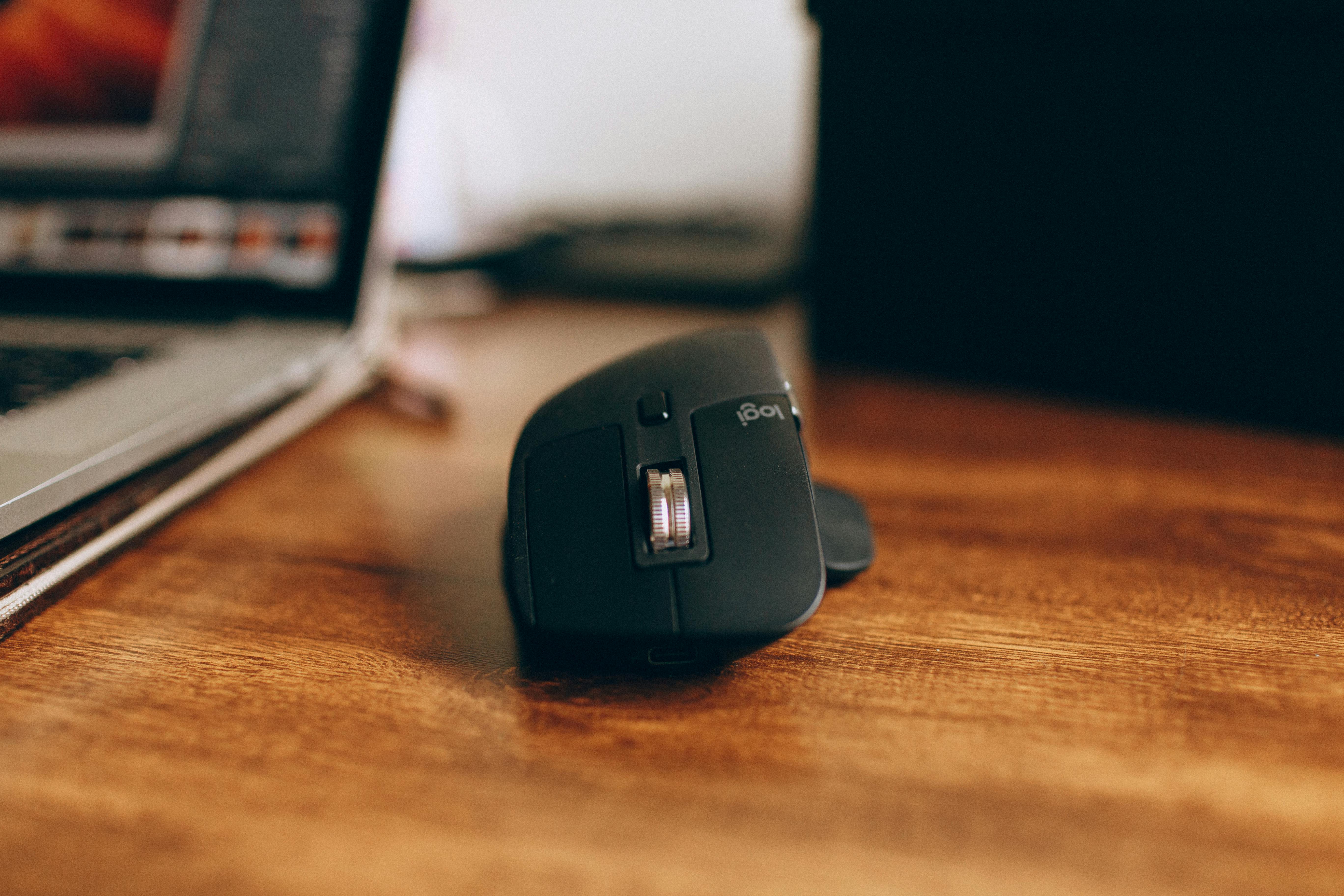 Black Wireless Computer Mouse on Brown Wooden Table · Free Stock Photo