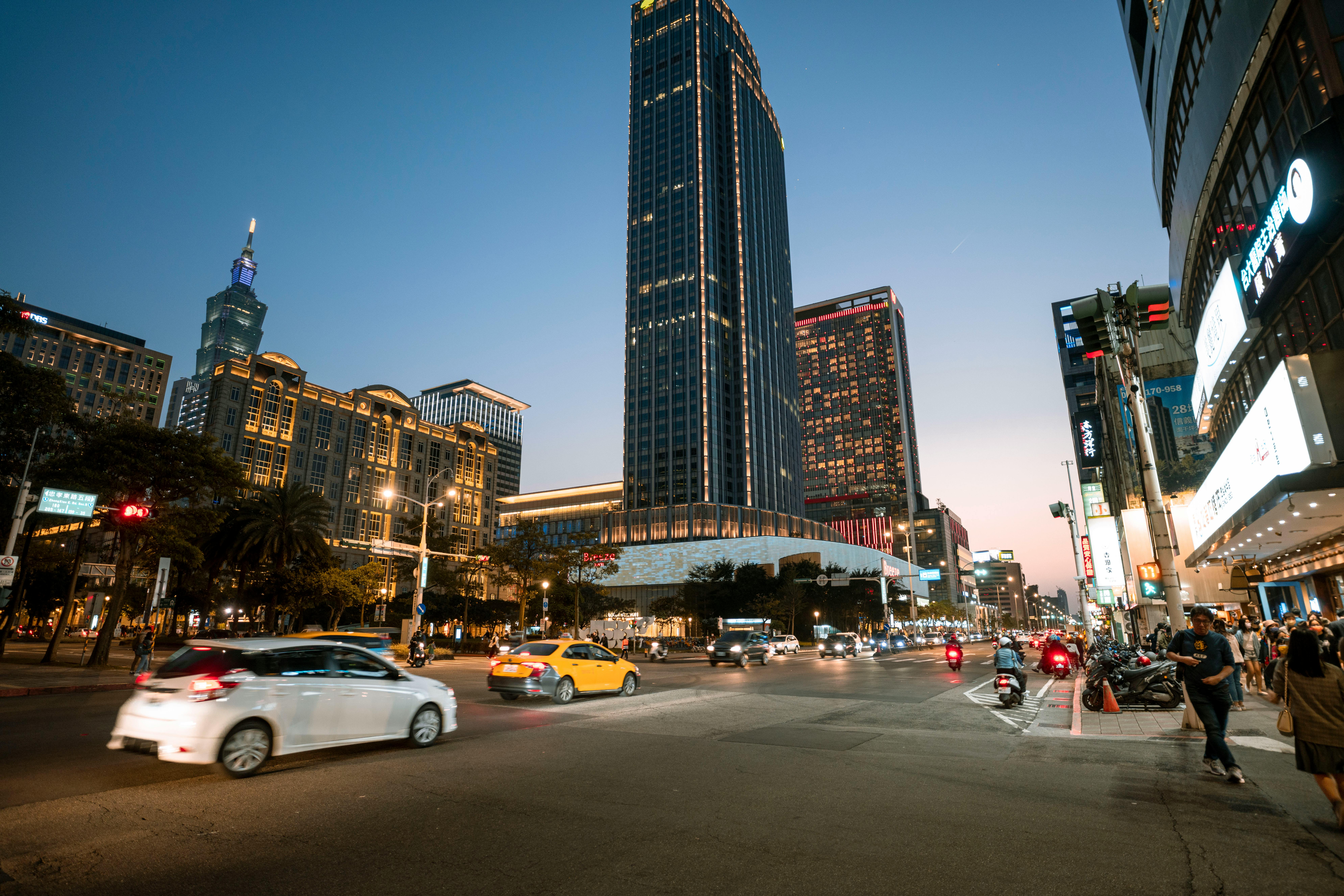 Illuminated buildings near road with transport in town · Free Stock Photo