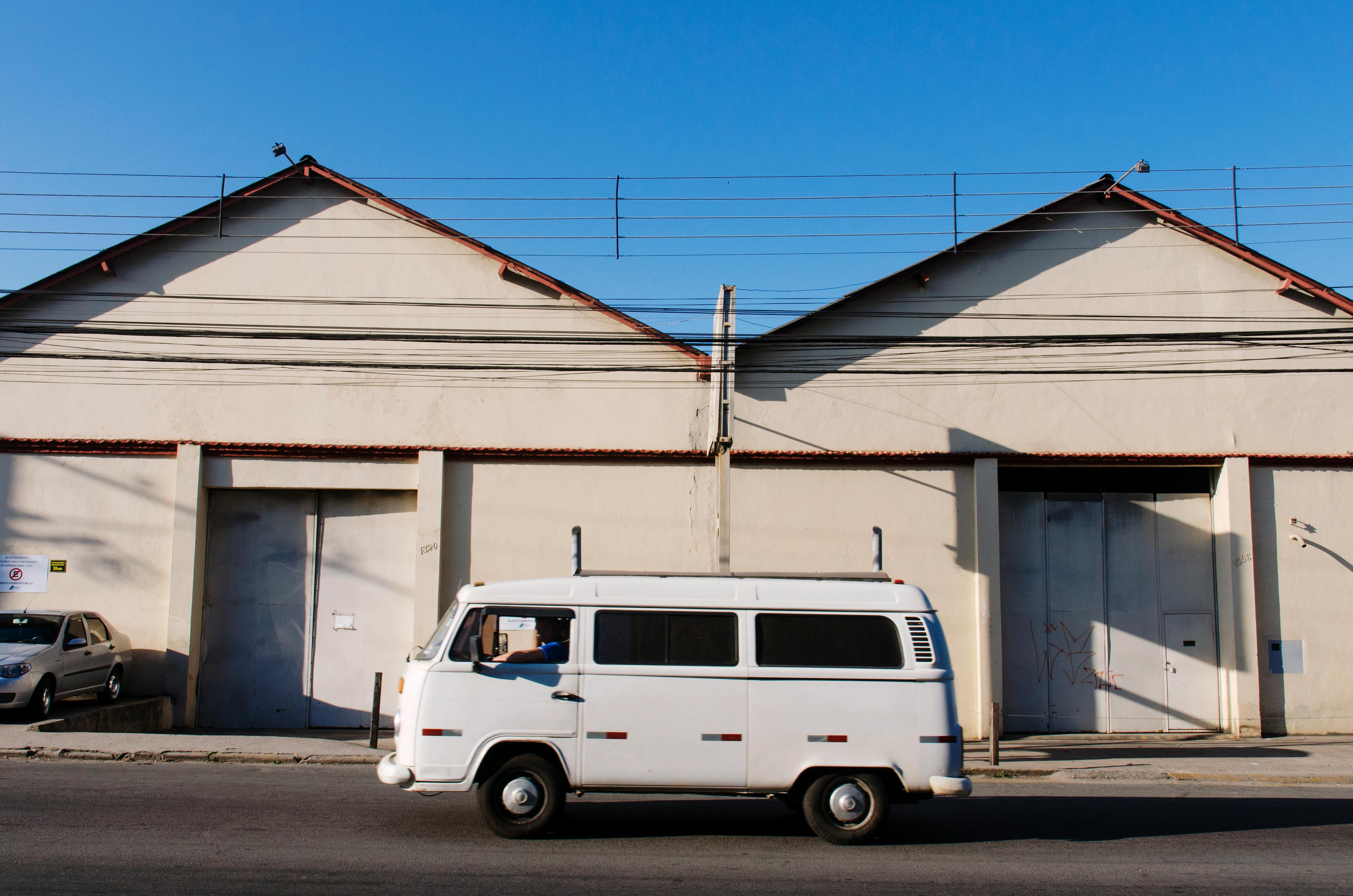 White Van Parked beside White Concrete Building · Free Stock Photo