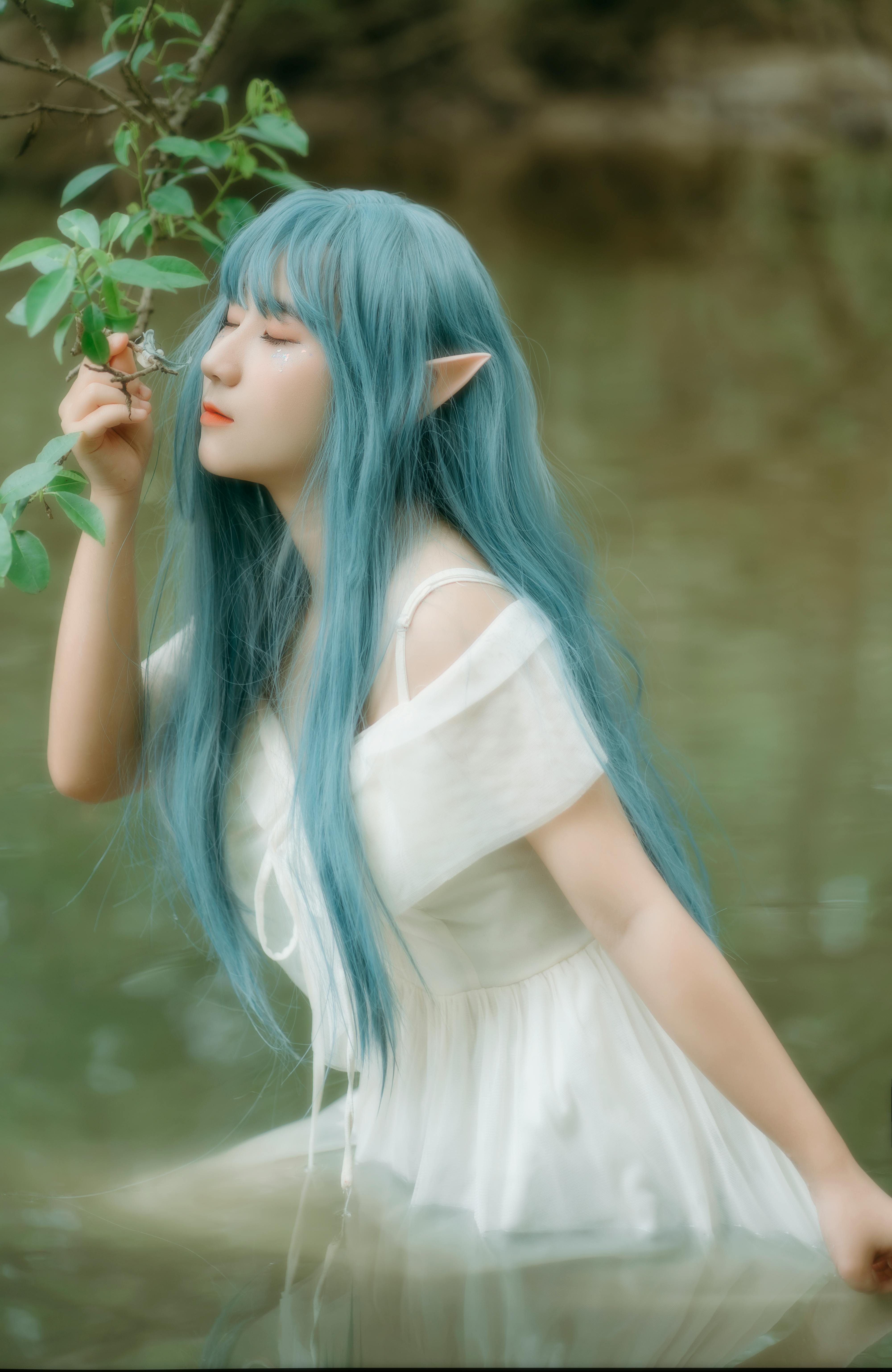 Creative Asian cosplayer with branch sitting in water · Free Stock Photo
