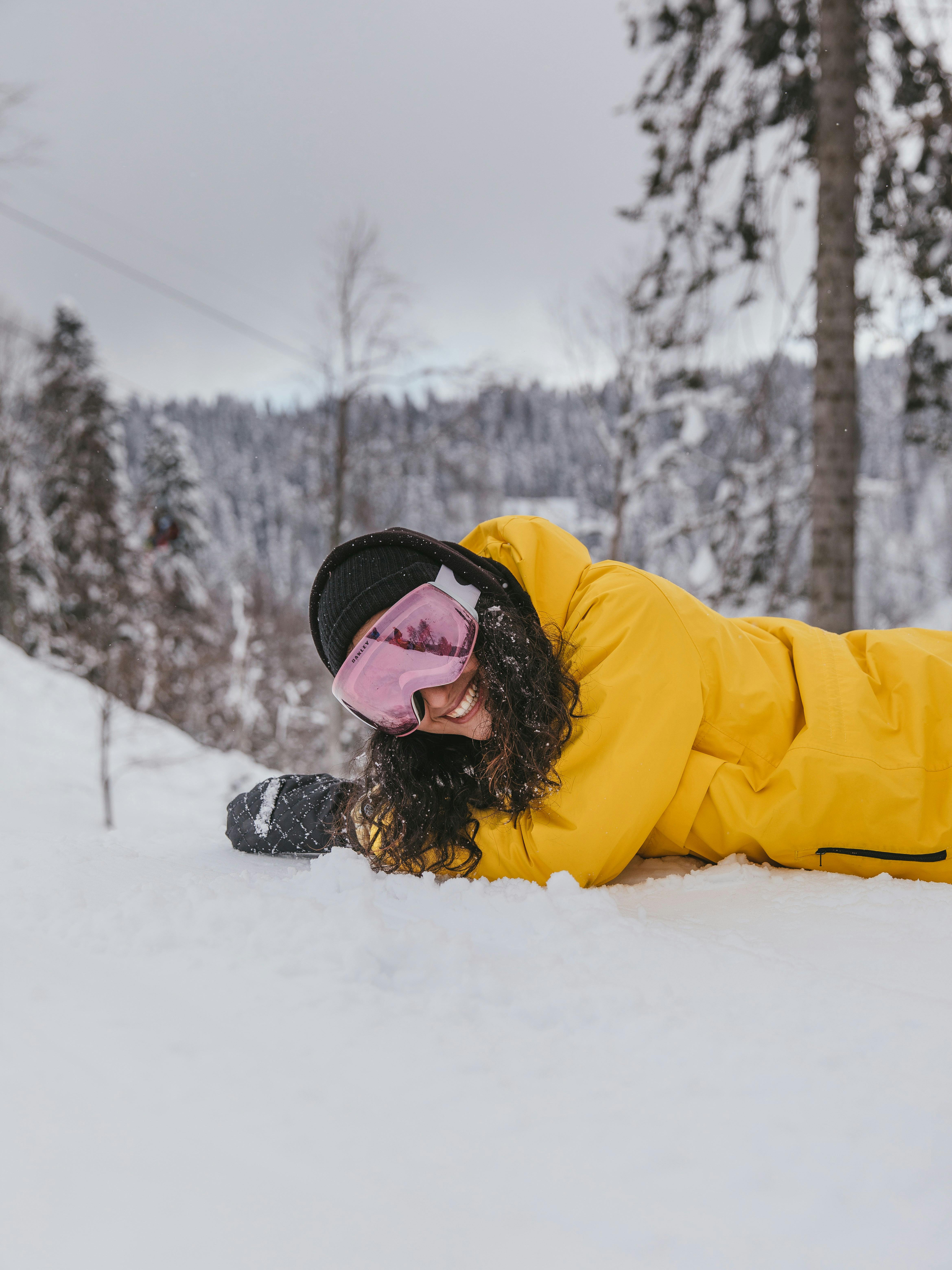 Woman in Yellow Jacket Lying on Snow · Free Stock Photo