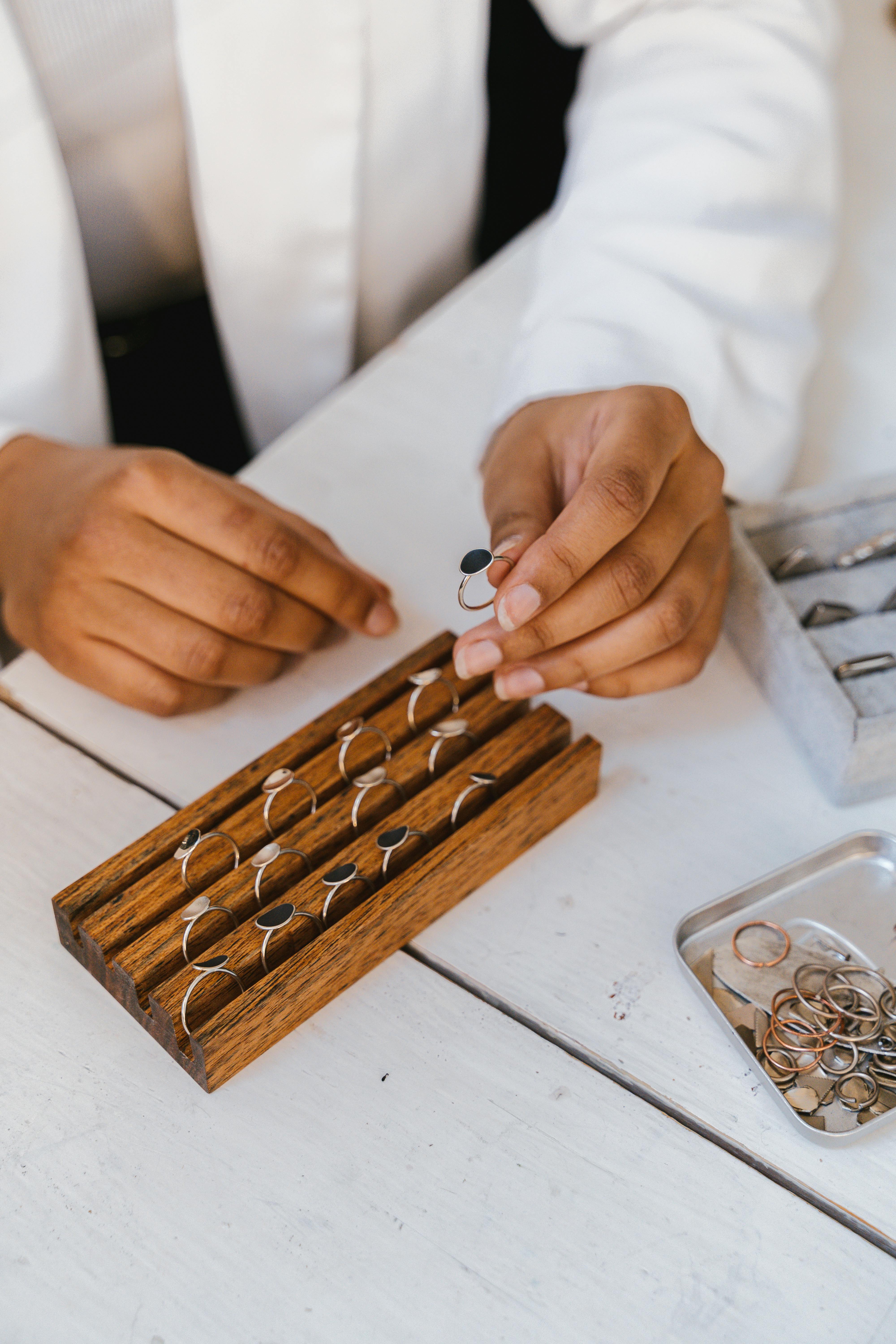 Hands Arranging Rings on Display · Free Stock Photo