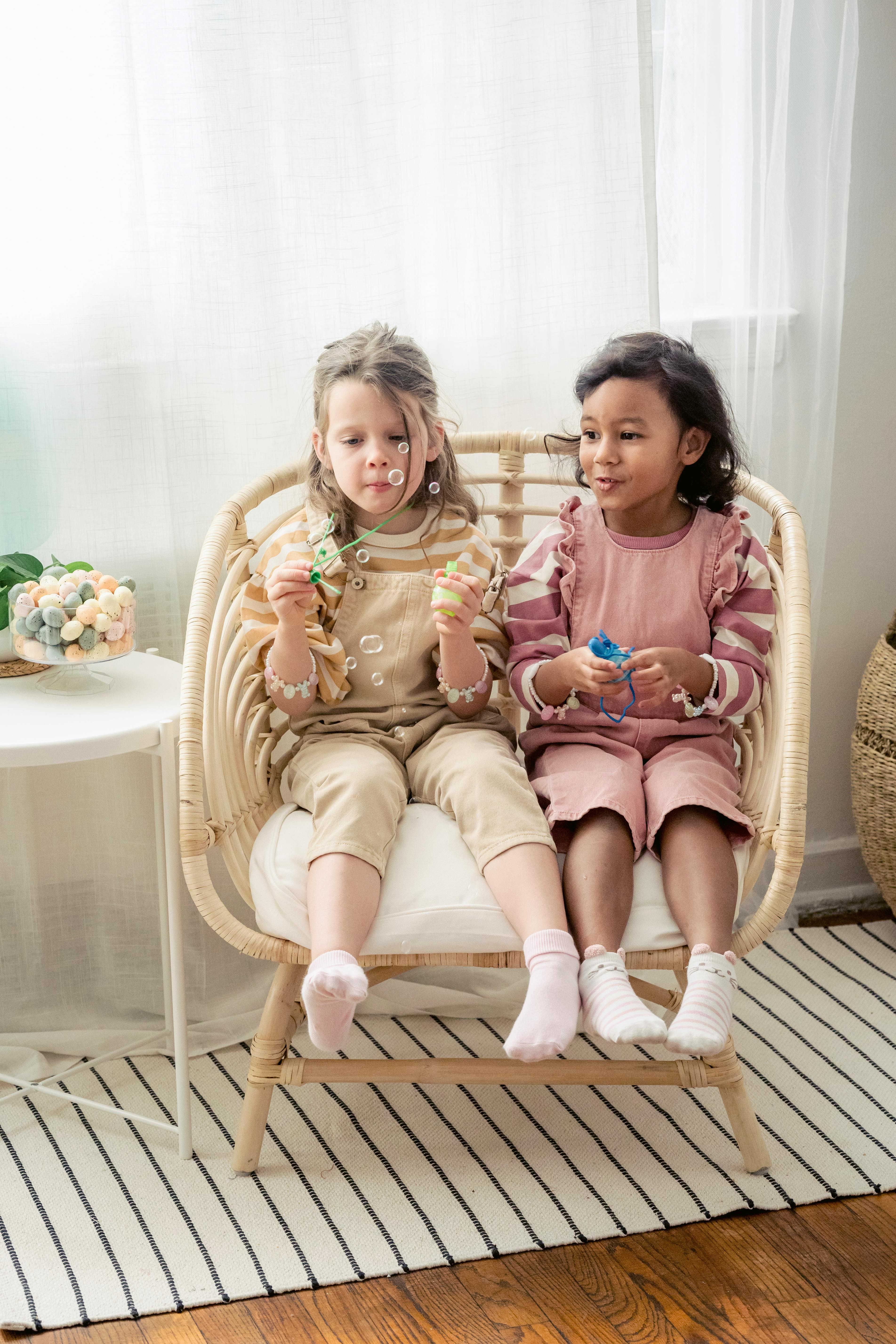 Two Girls Sitting on Rattan Chair Playing with Soap Bubbles · Free ...