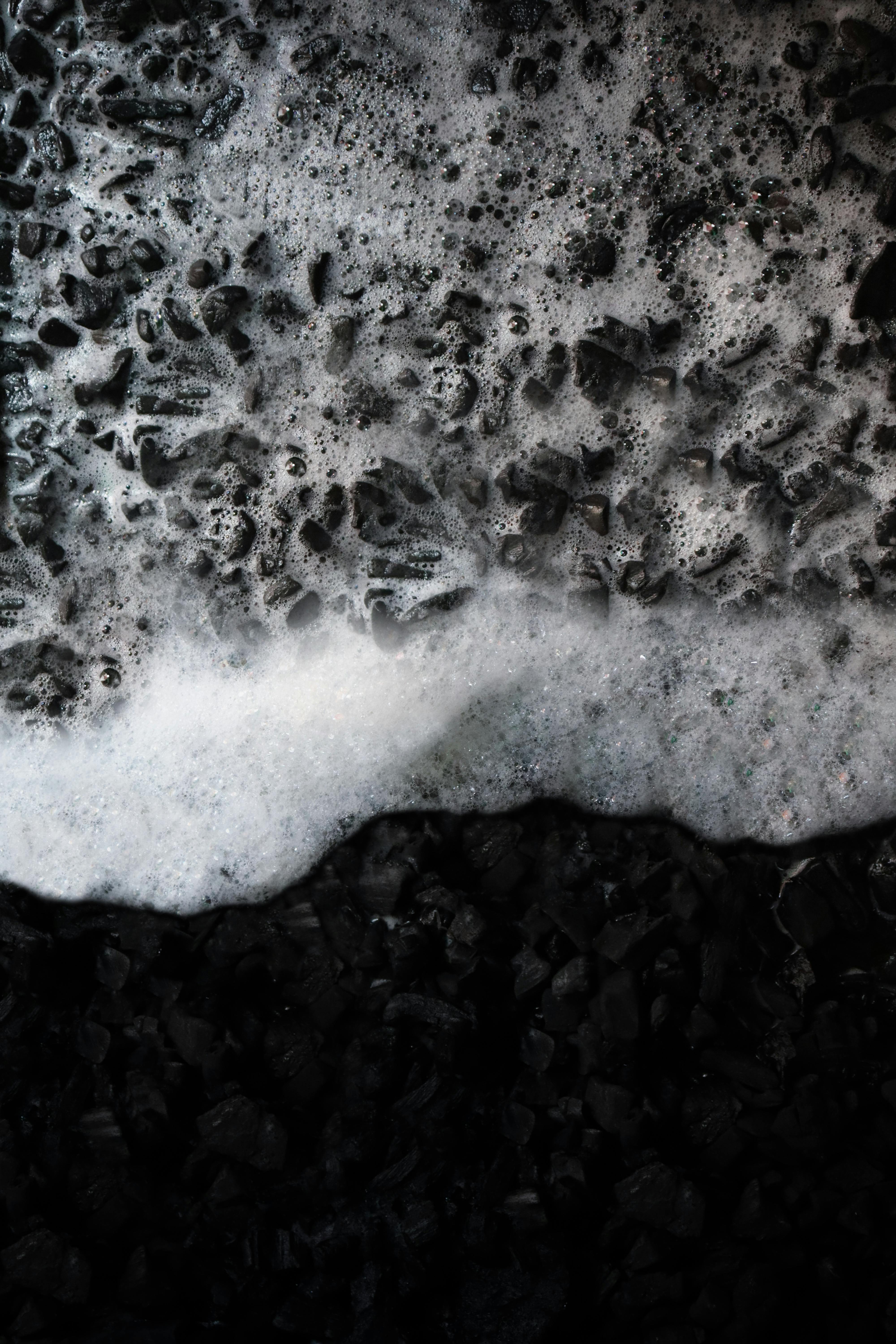 Water Splashing on Black Stones on Beach · Free Stock Photo