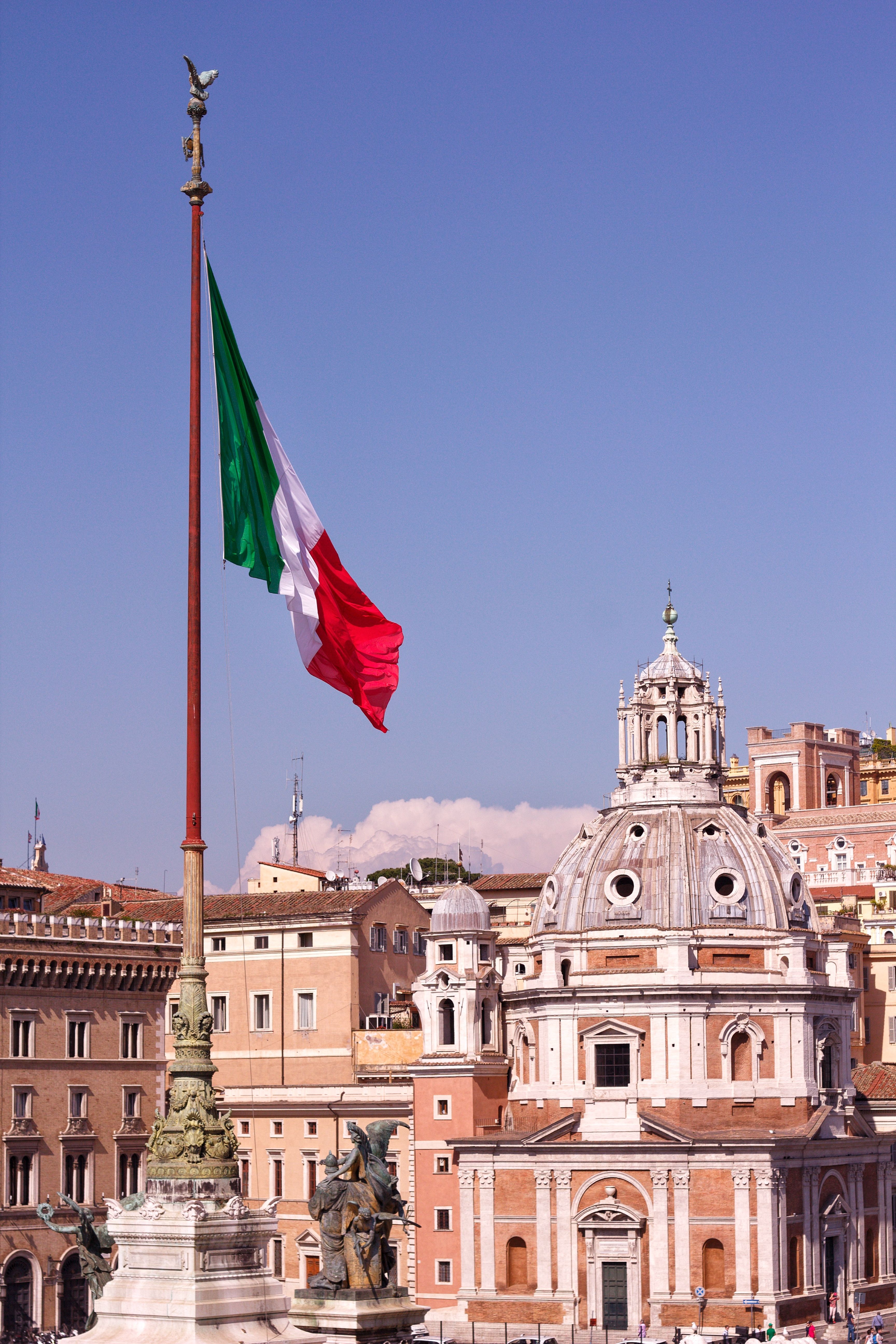A Flag Pole Near the Concrete Buildings · Free Stock Photo