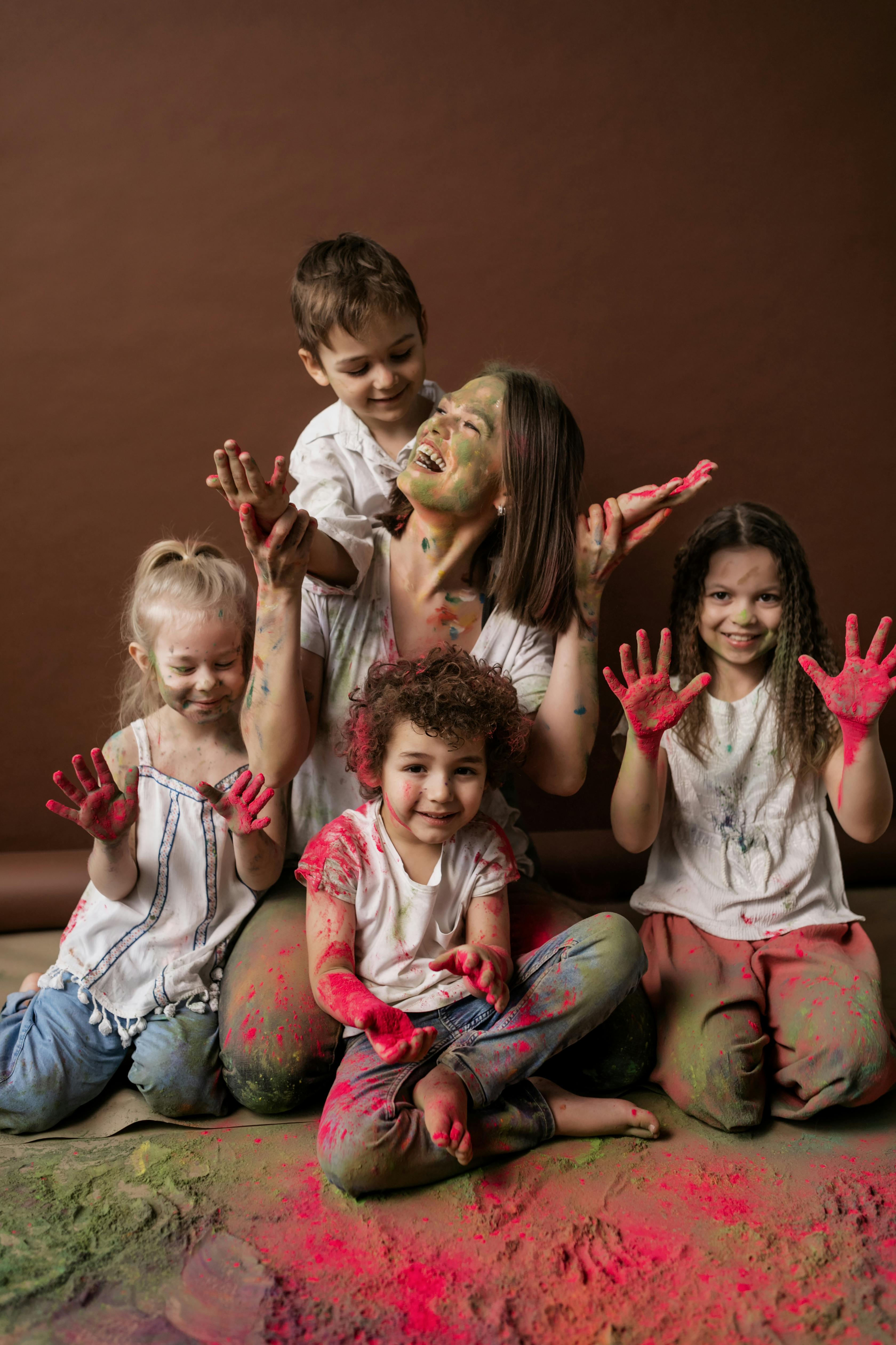 A Woman Playing Colored Powders With Kids · Free Stock Photo