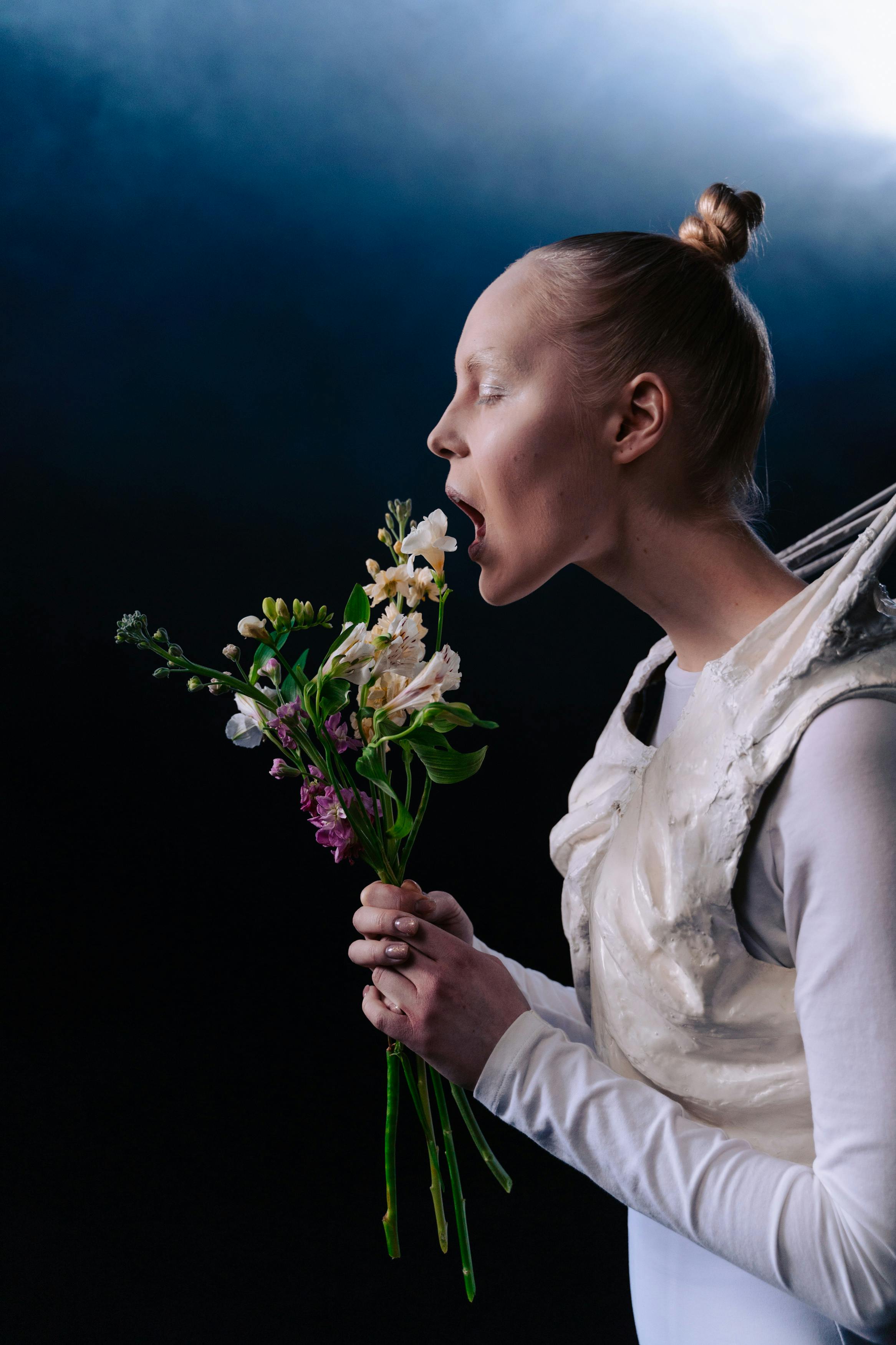Side View of a Woman Eating Flowers · Free Stock Photo