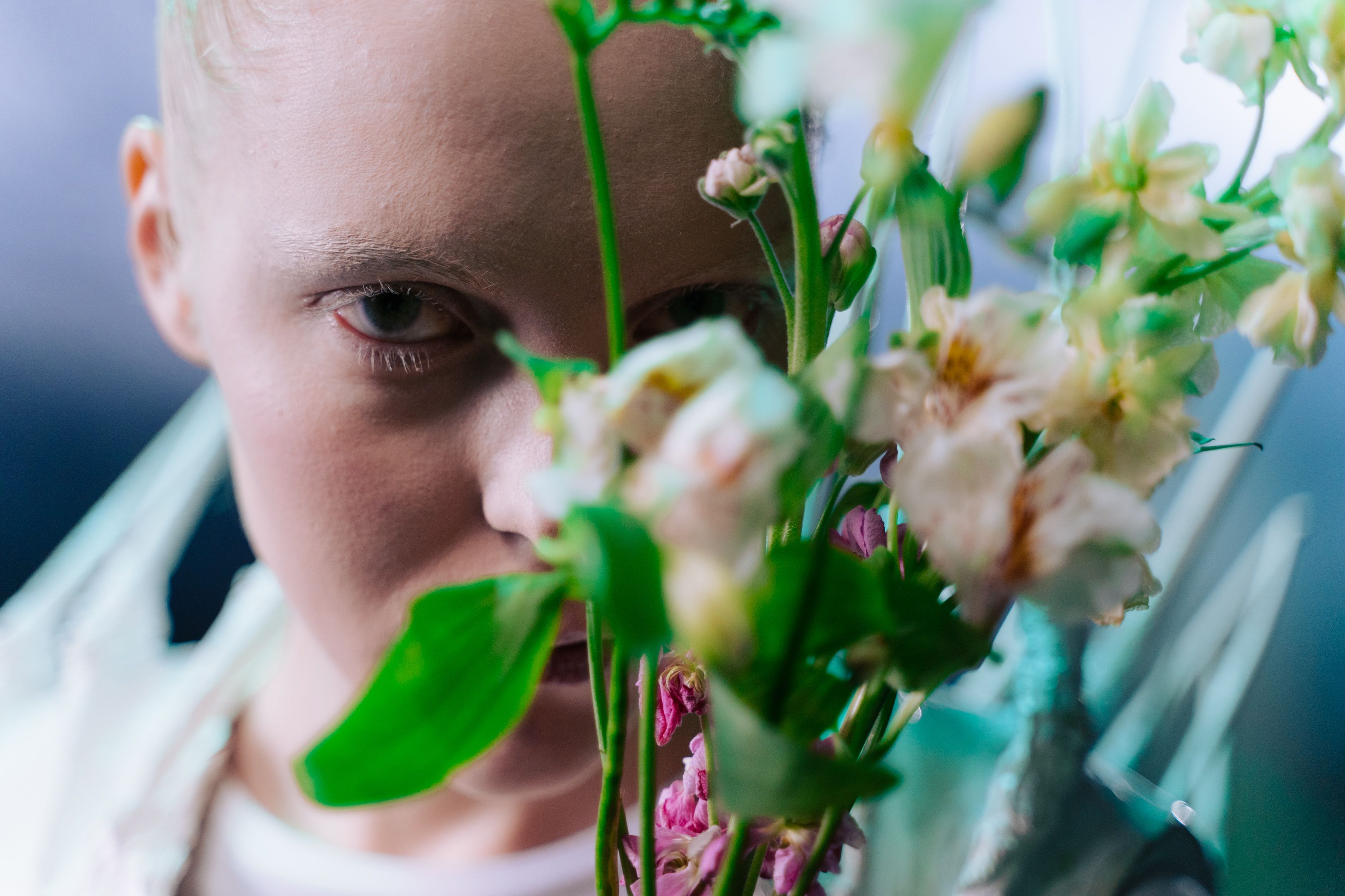 Close-up Shot of a Woman Behind Bunch of Flowers Seriously Looking at ...