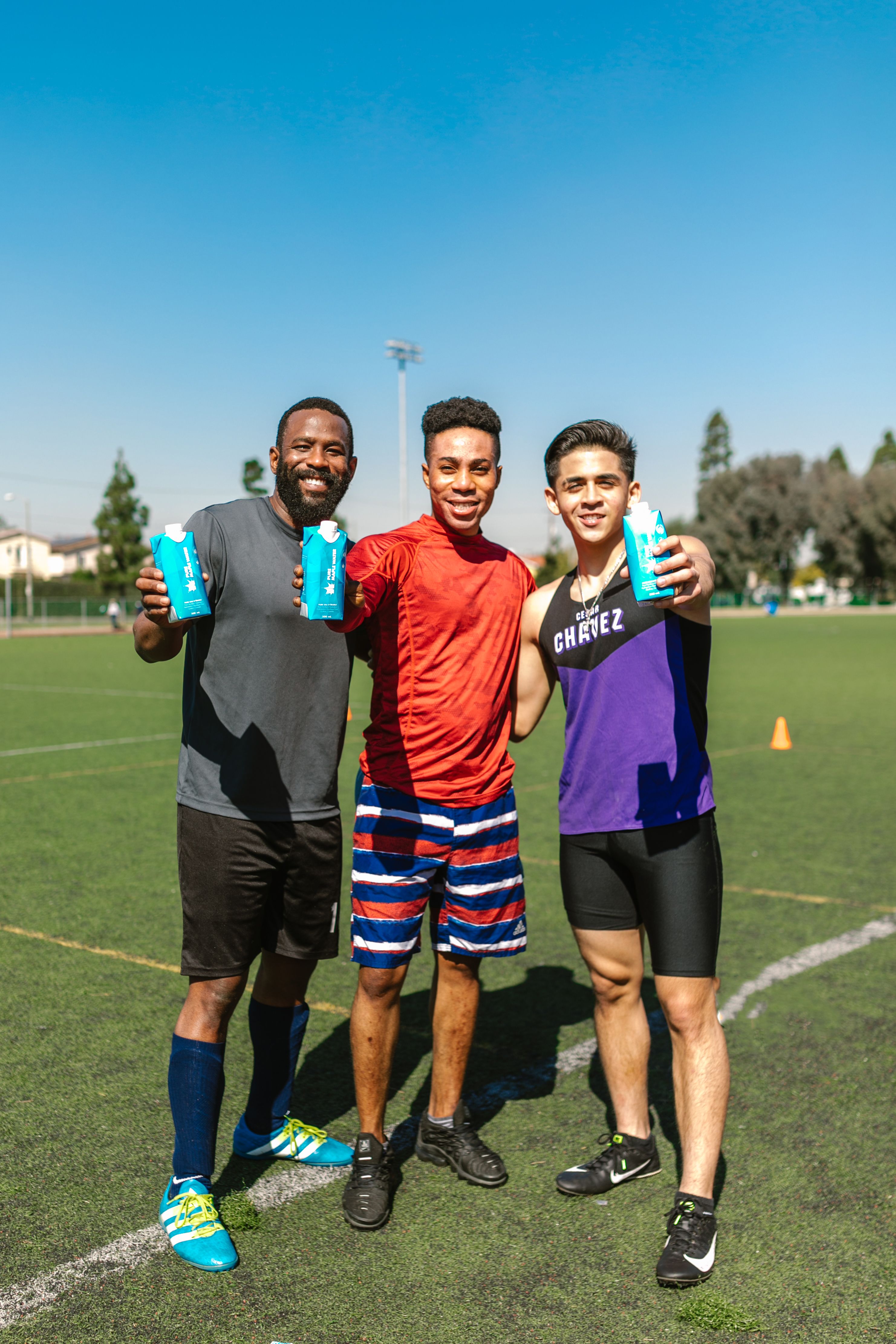 Men in Sport Wear Standing Side by Side on Green Grass · Free Stock Photo