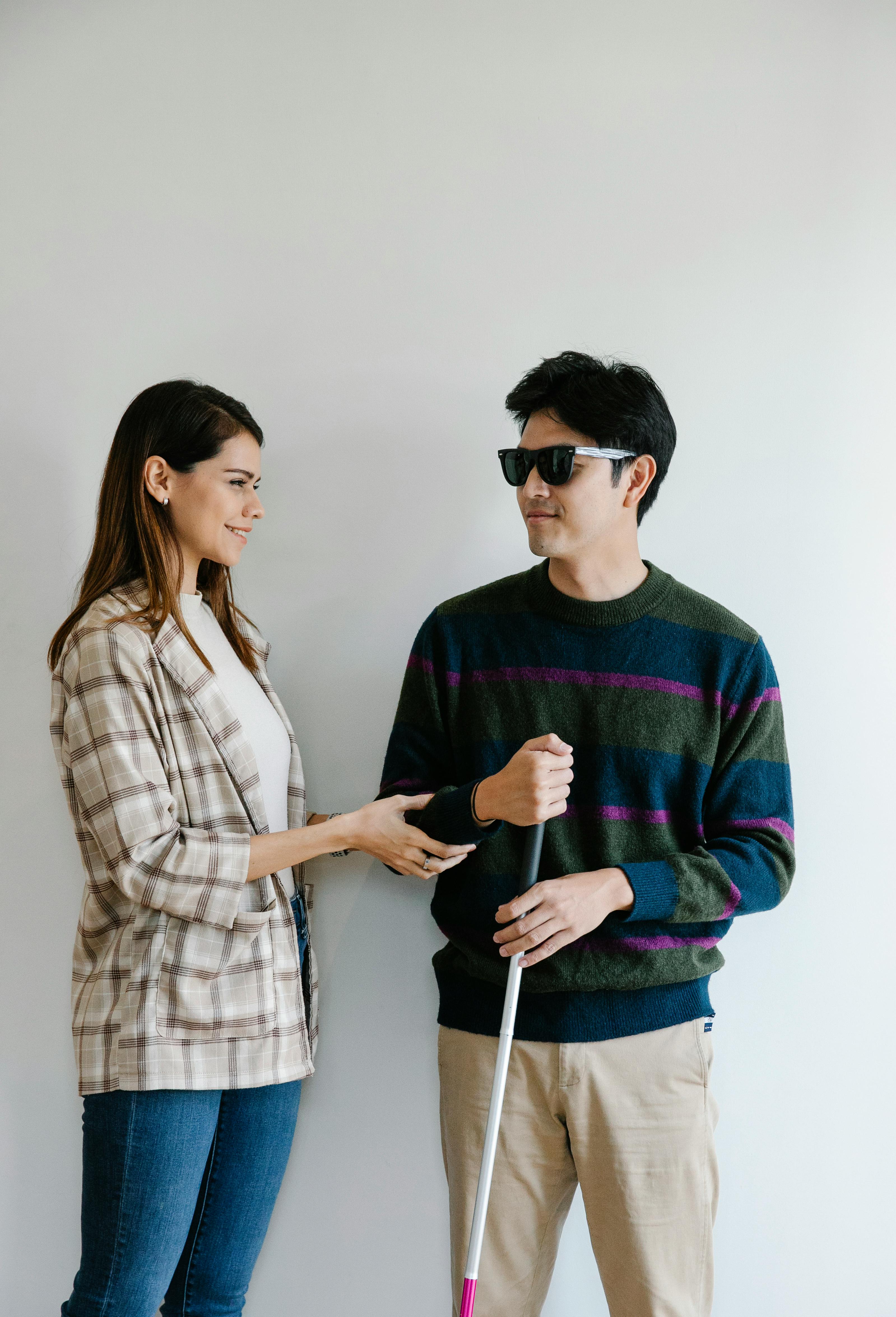 Photo of Woman Cheerfully Assisting Blind Man · Free Stock Photo