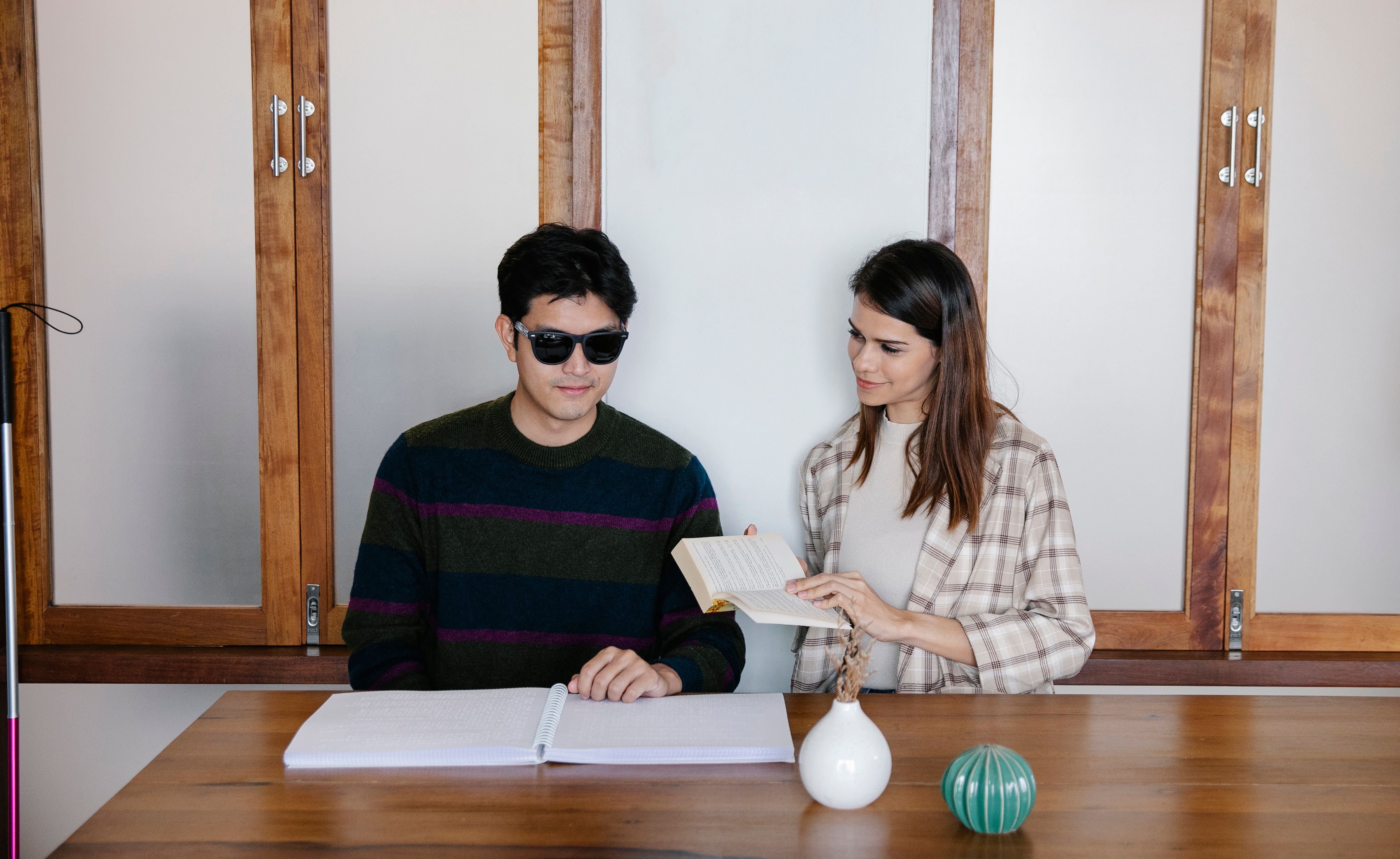 Photo of People Sitting Together Beside Wooden Table · Free Stock Photo