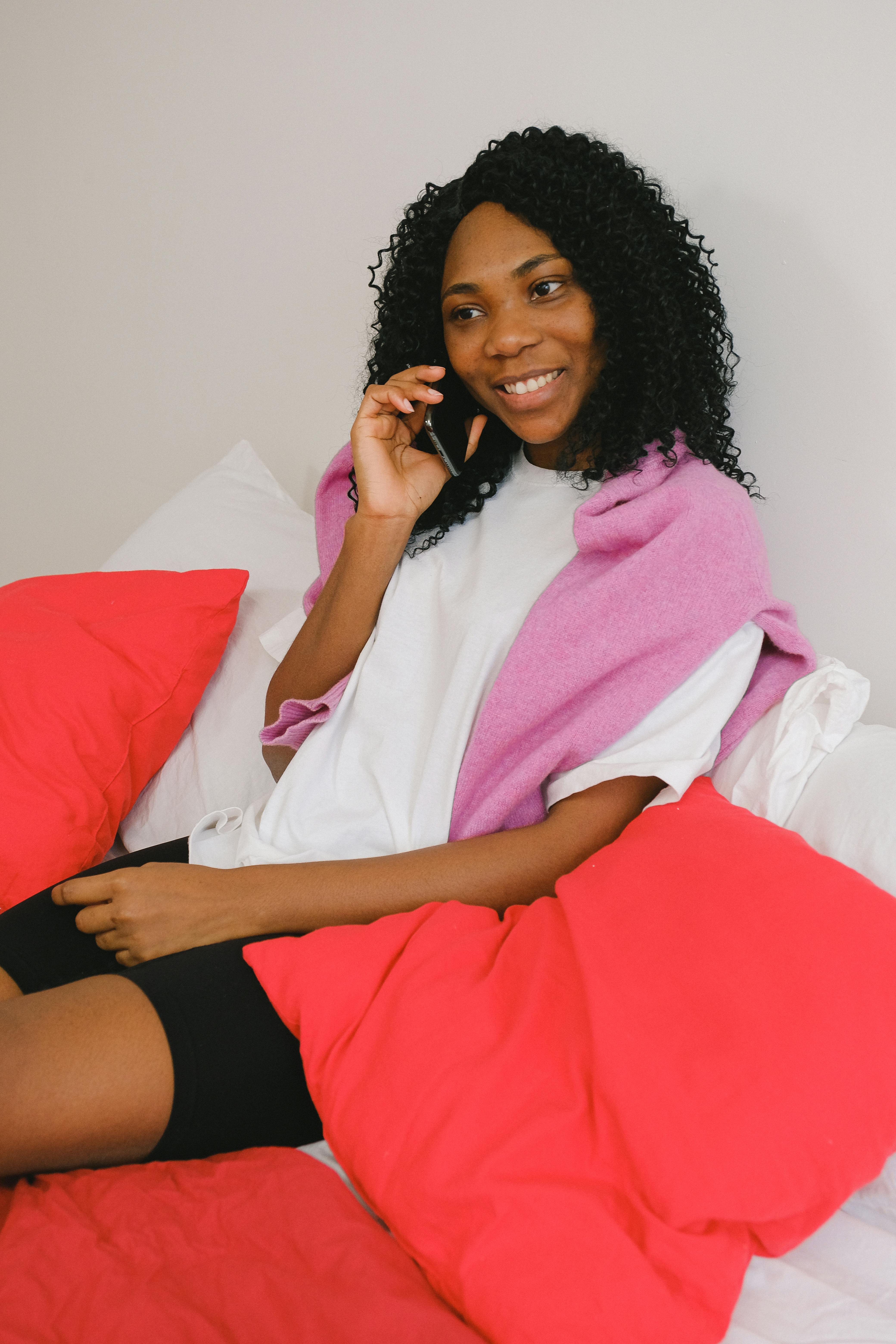 Smiling black woman having phone call in bedroom · Free Stock Photo