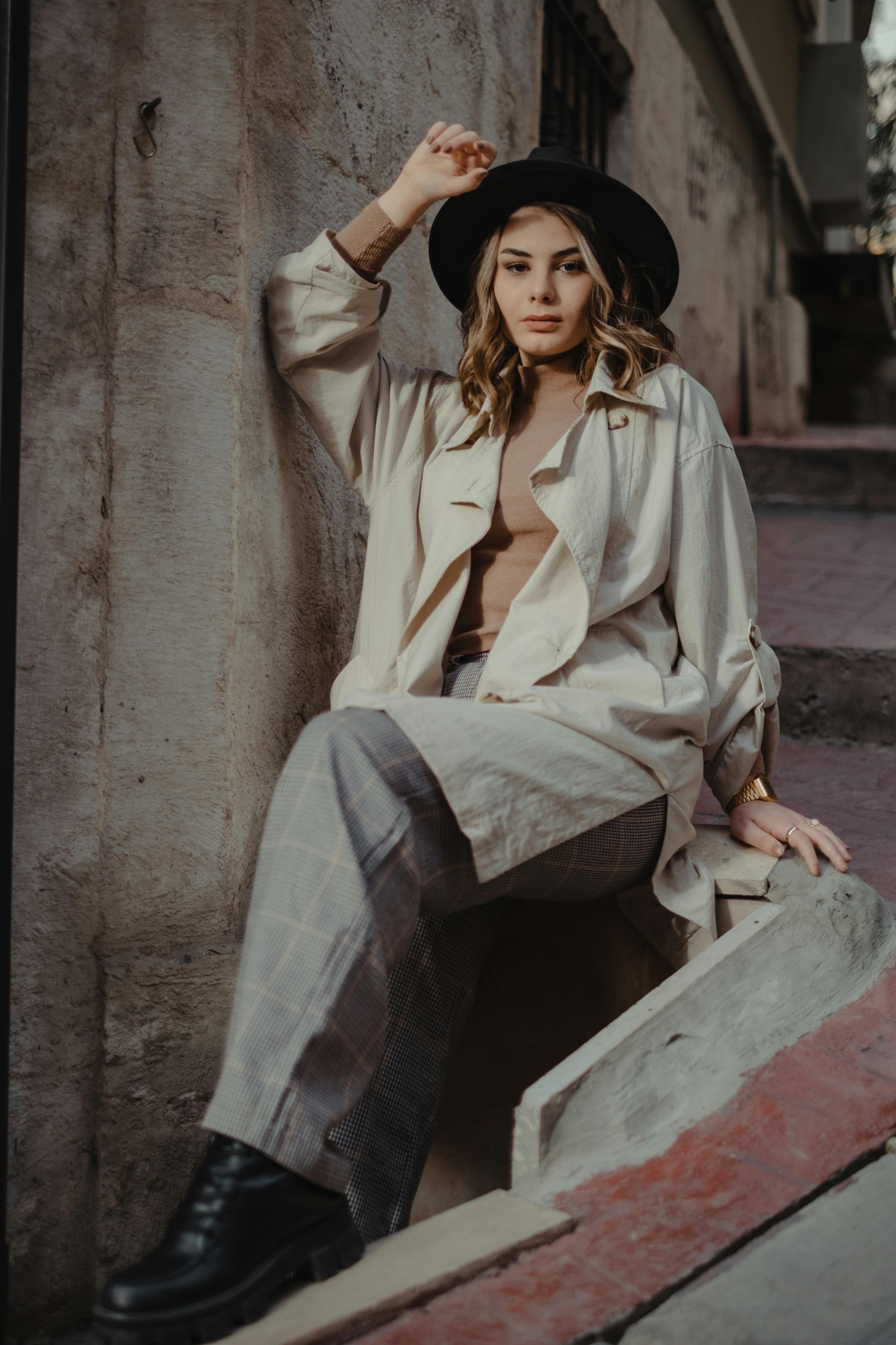 Stylish woman in fashionable outfit standing near concrete wall · Free ...