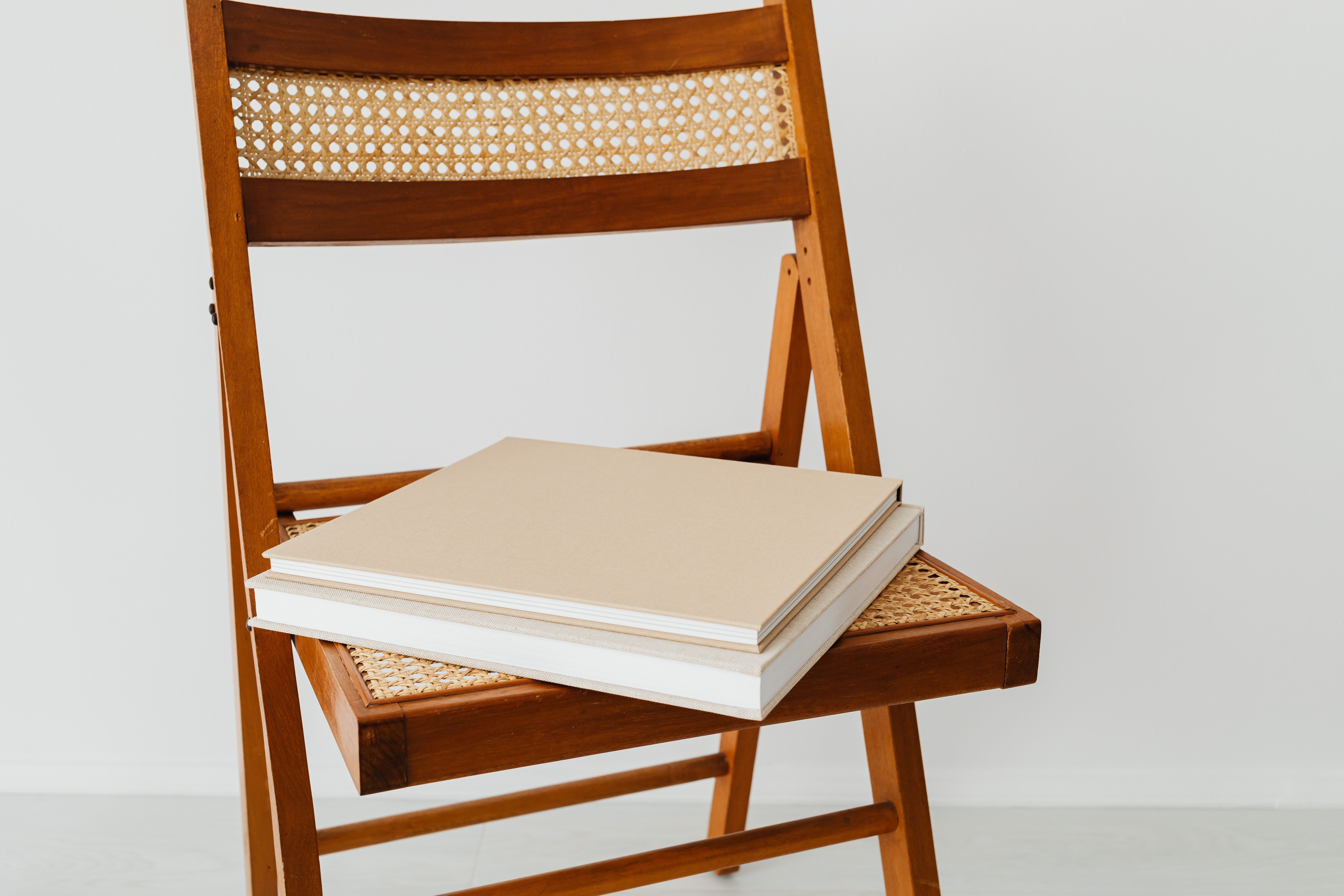 White Books on Top of Brown Chair · Free Stock Photo
