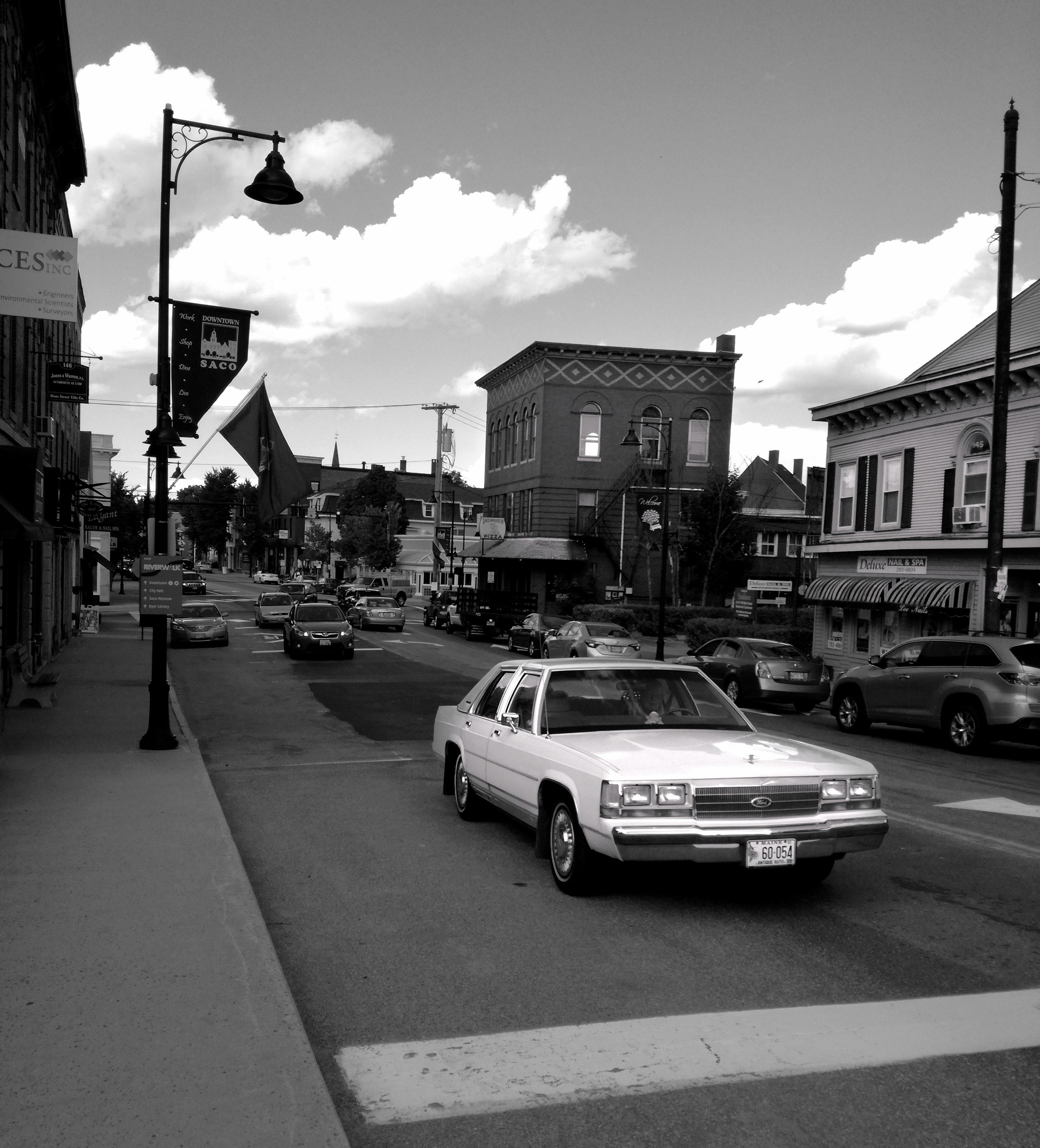 A Grayscale Photo of a Vintage Car on the Road · Free Stock Photo
