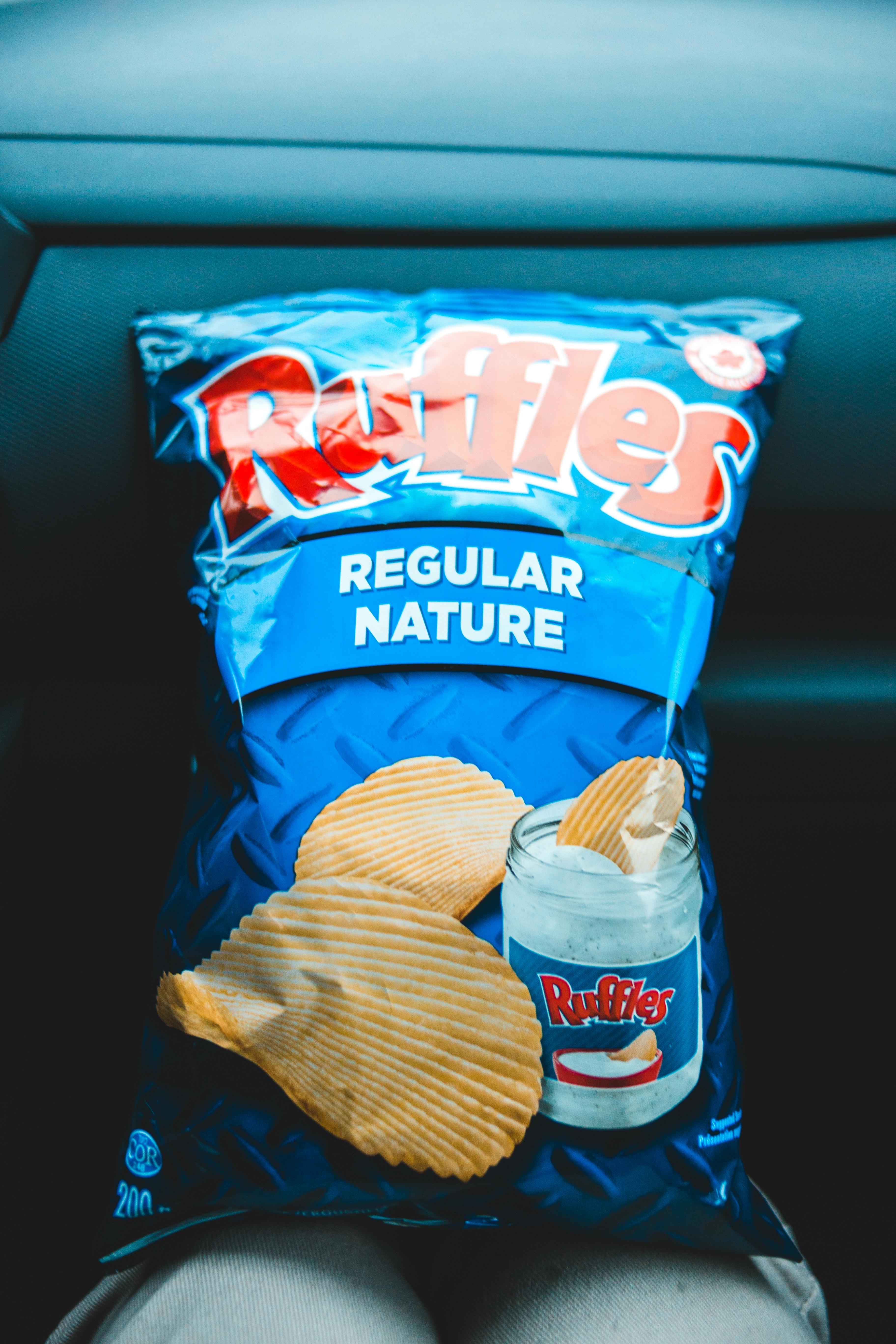 Snack in blue packaging placed on knees · Free Stock Photo