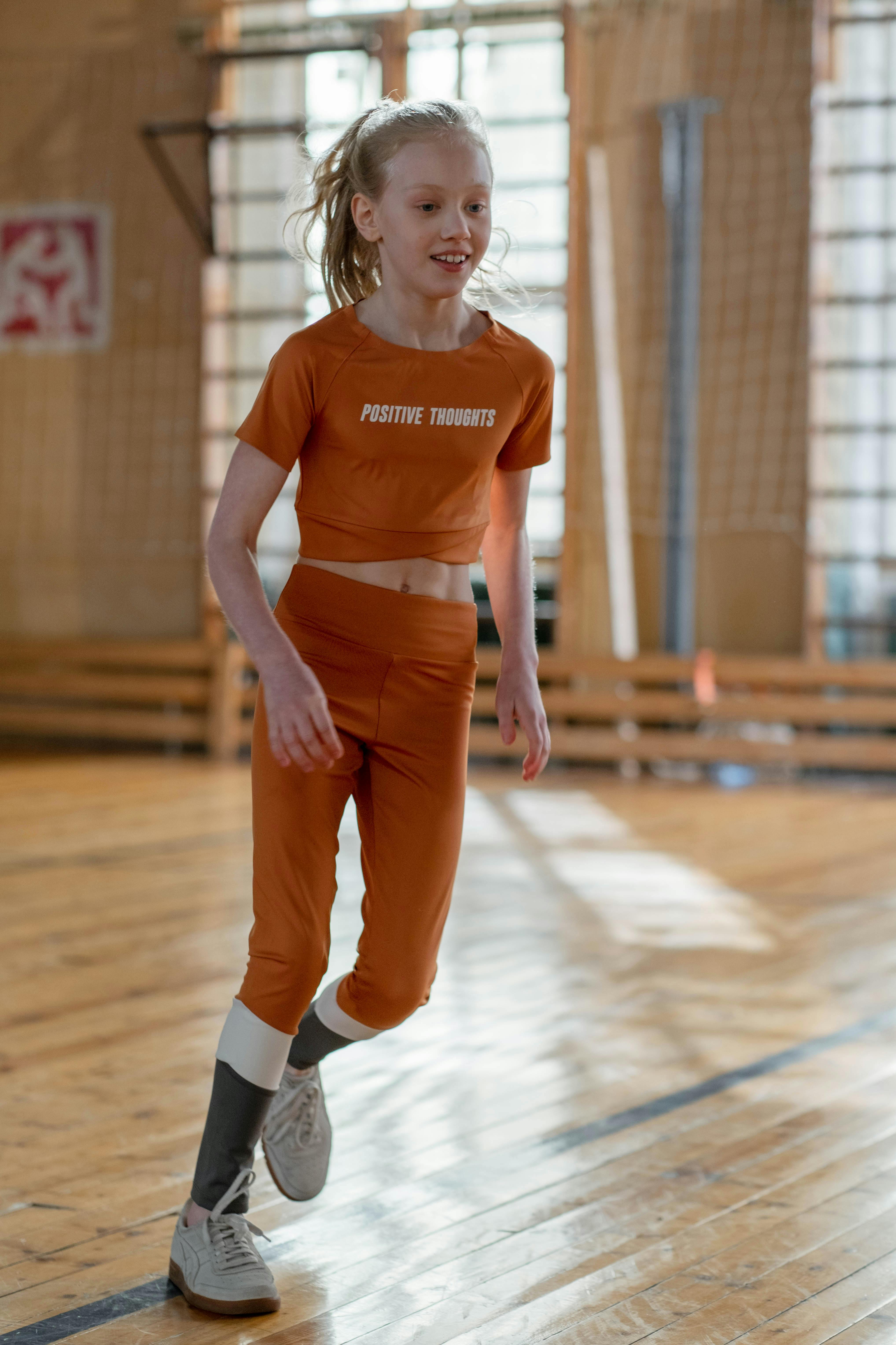 Woman in Orange Sports Wear Doing Cartwheel · Free Stock Photo