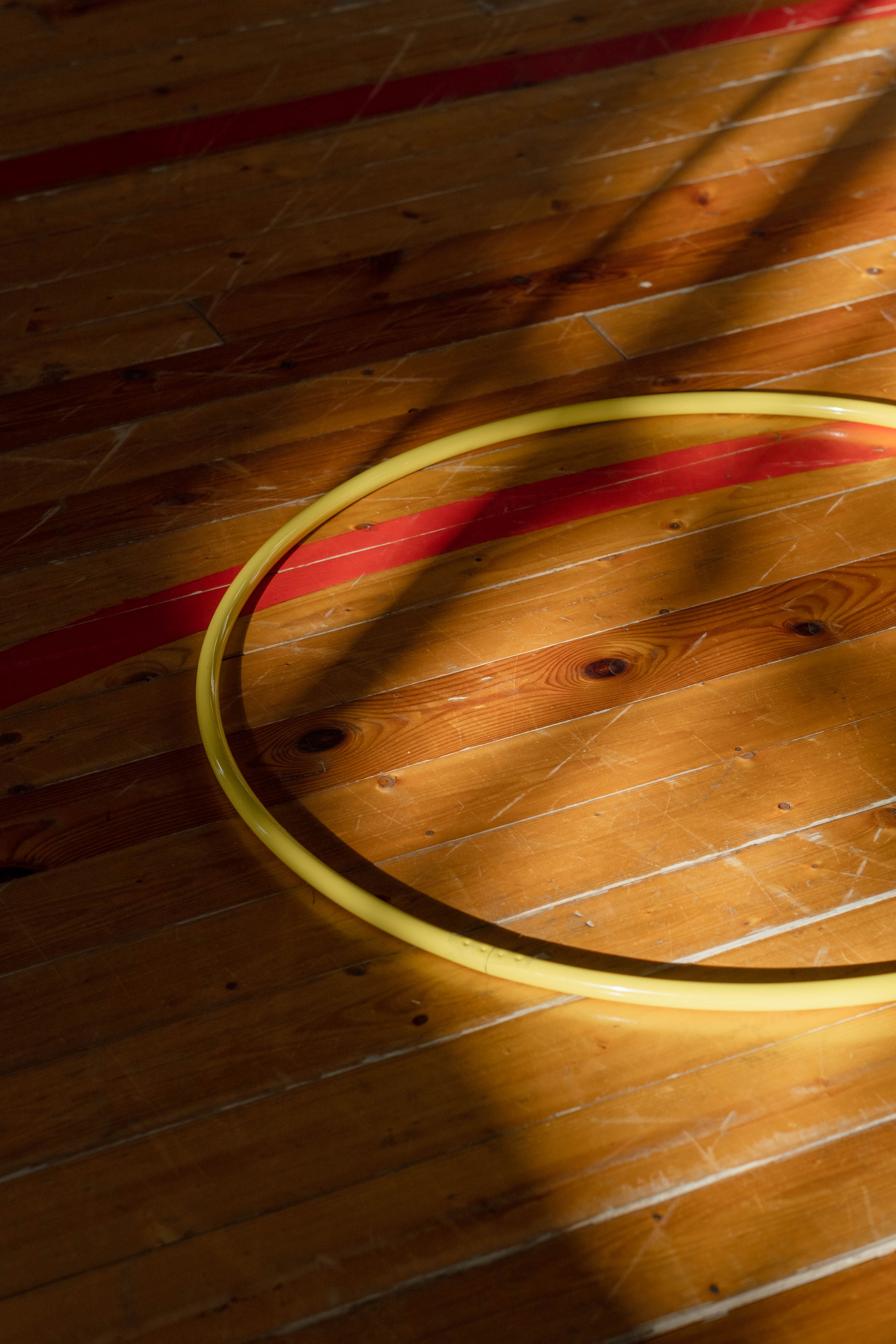 Hula Hoop on the Wooden Floor Lit by Daylight · Free Stock Photo