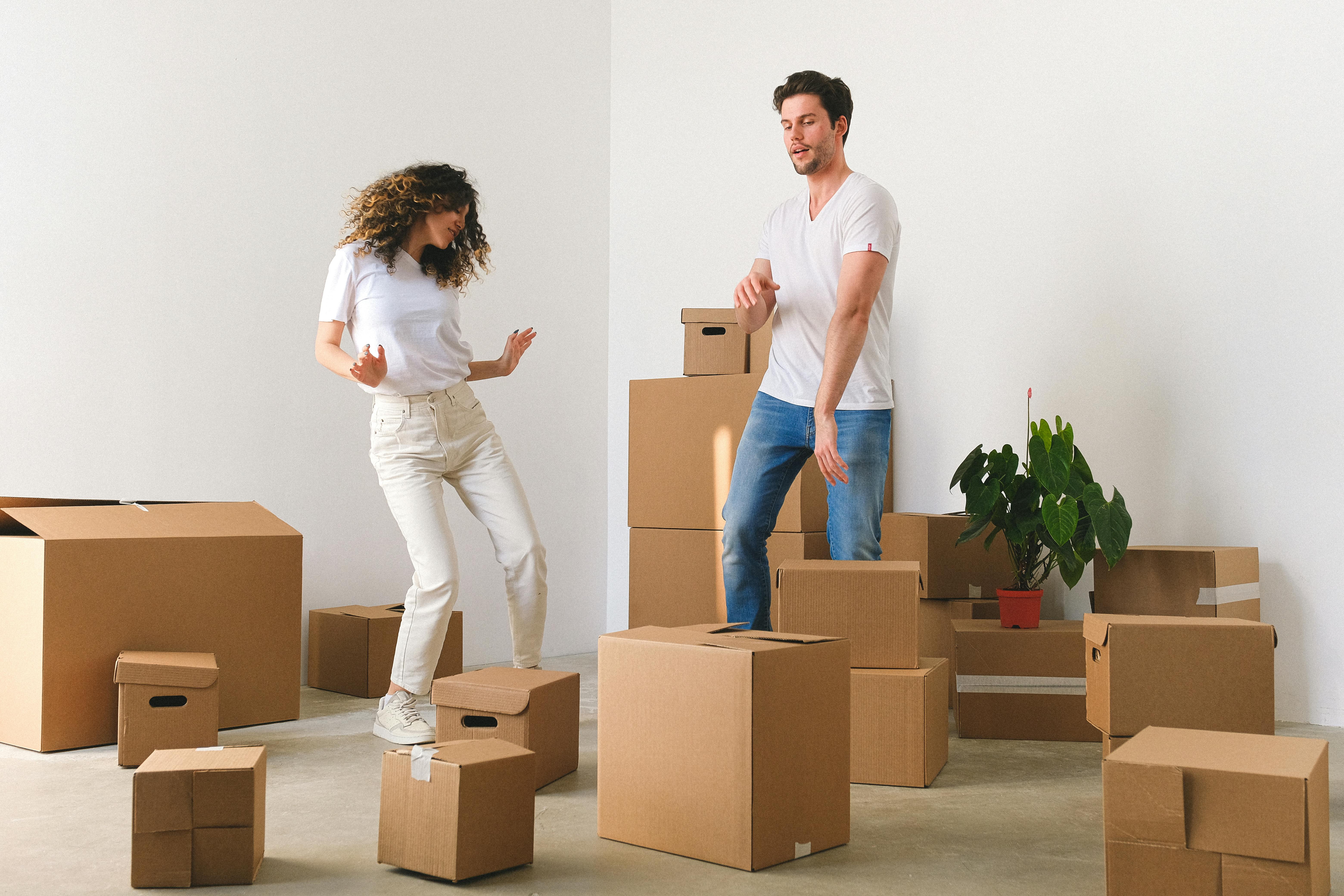 Man and Woman Dancing Around the Boxes · Free Stock Photo
