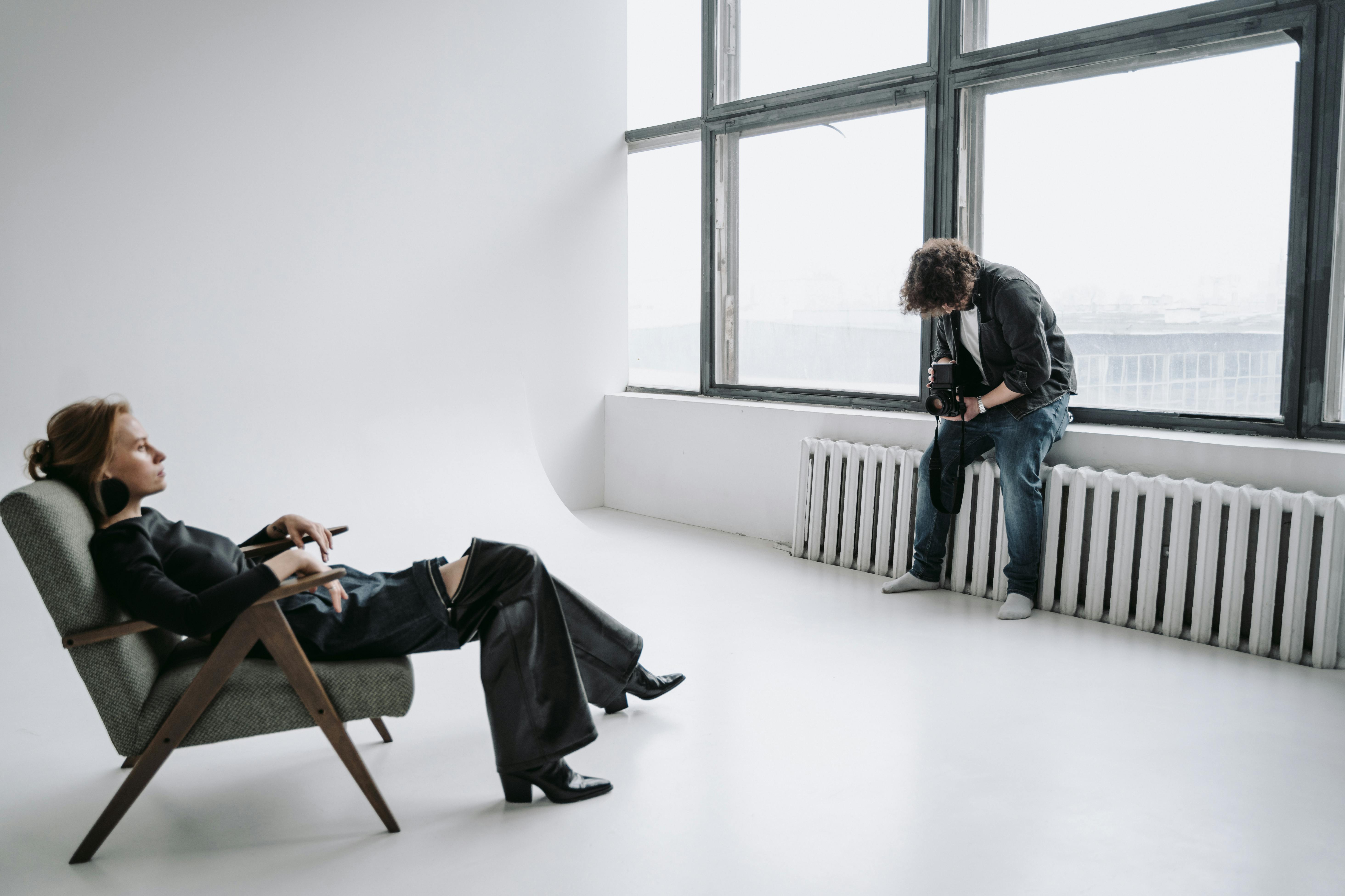 A Photographer Sitting on a Windowsill while Taking Photos of the Model ...