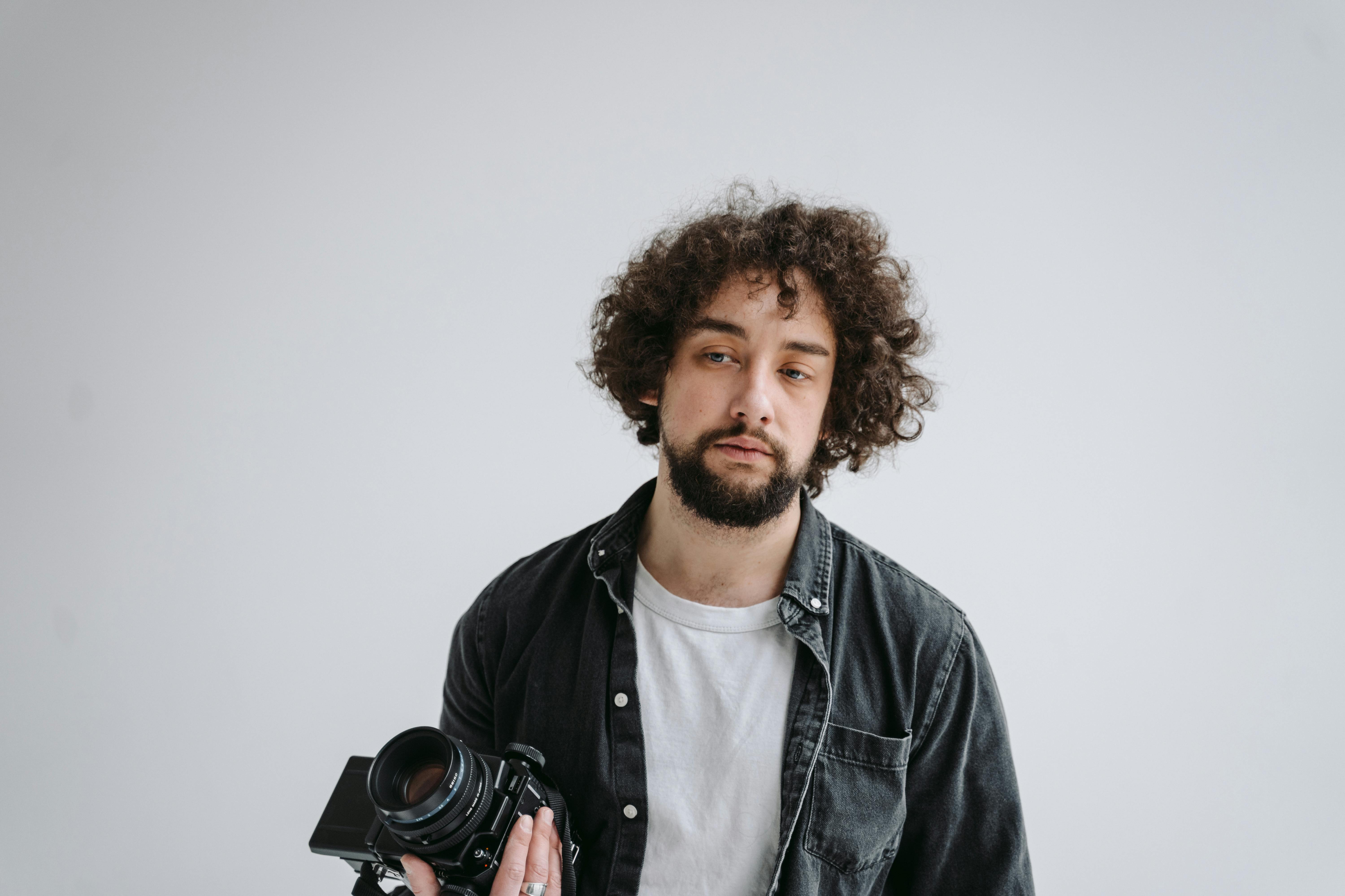 Grayscale Portrait Photo of Man Wearing Holding a Camera · Free Stock Photo