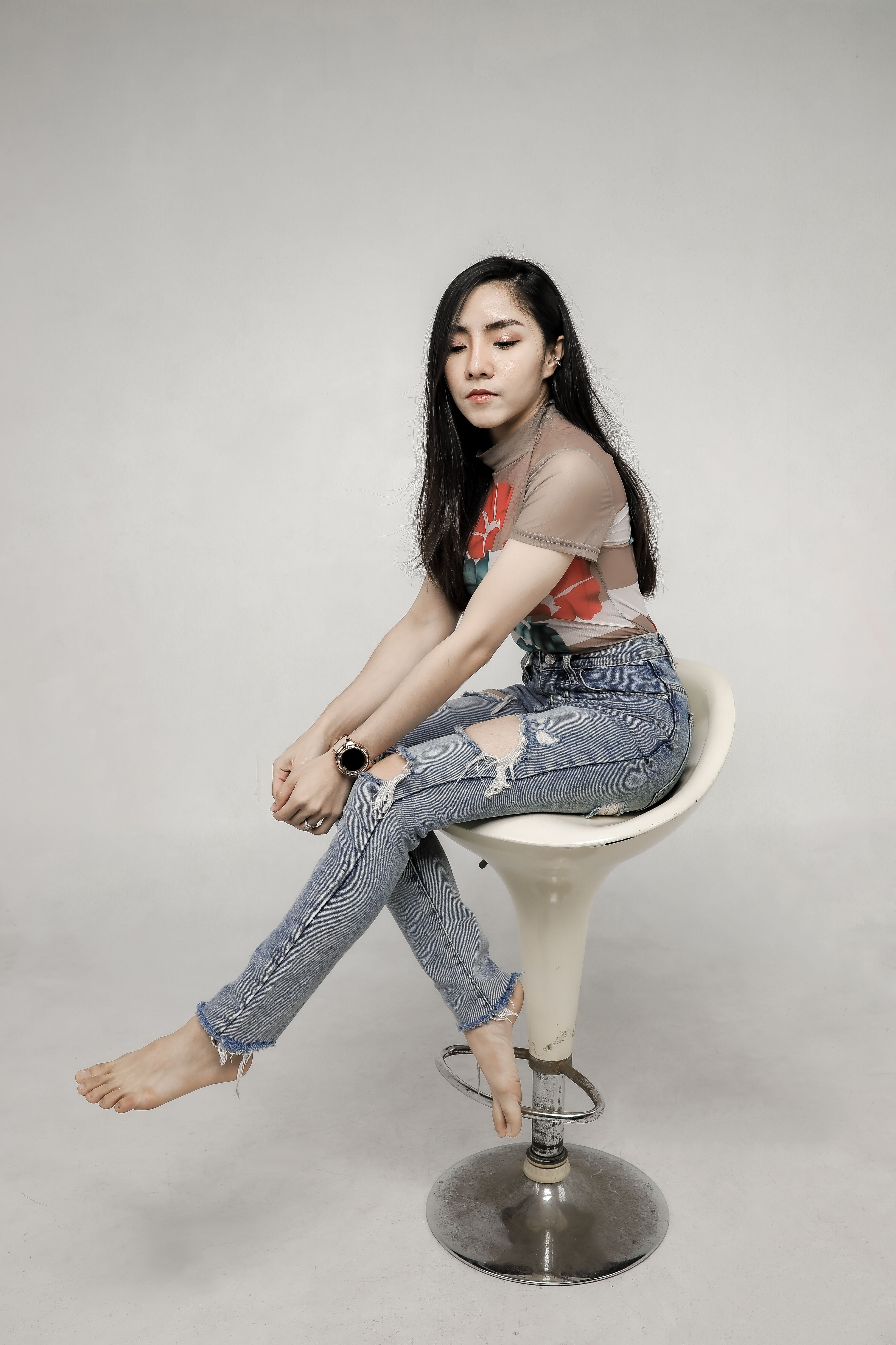 Photo of a Woman Wearing Denim Pants Sitting on a White Chair · Free ...
