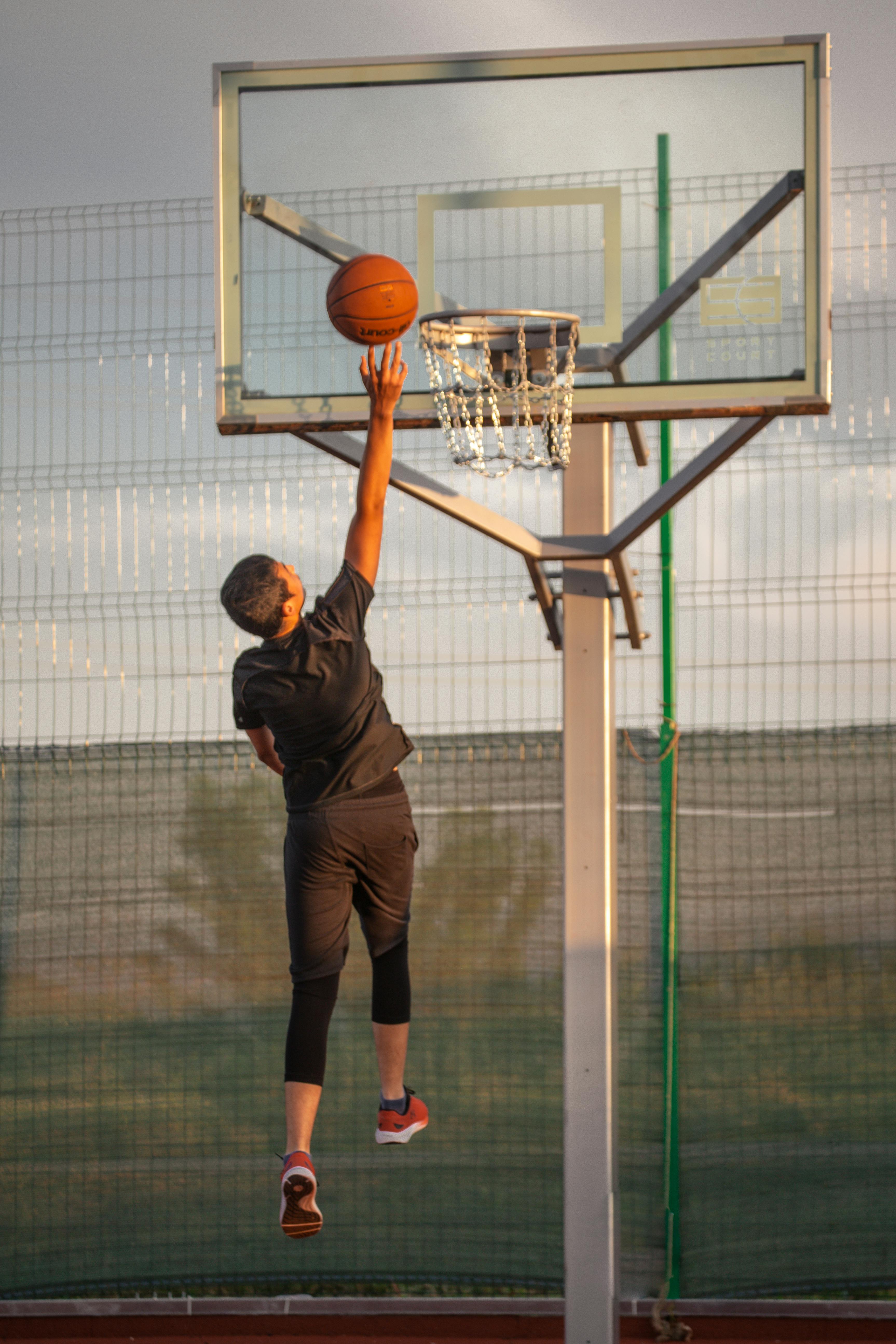 Basketball player throwing ball into basketball hoop · Free Stock Photo