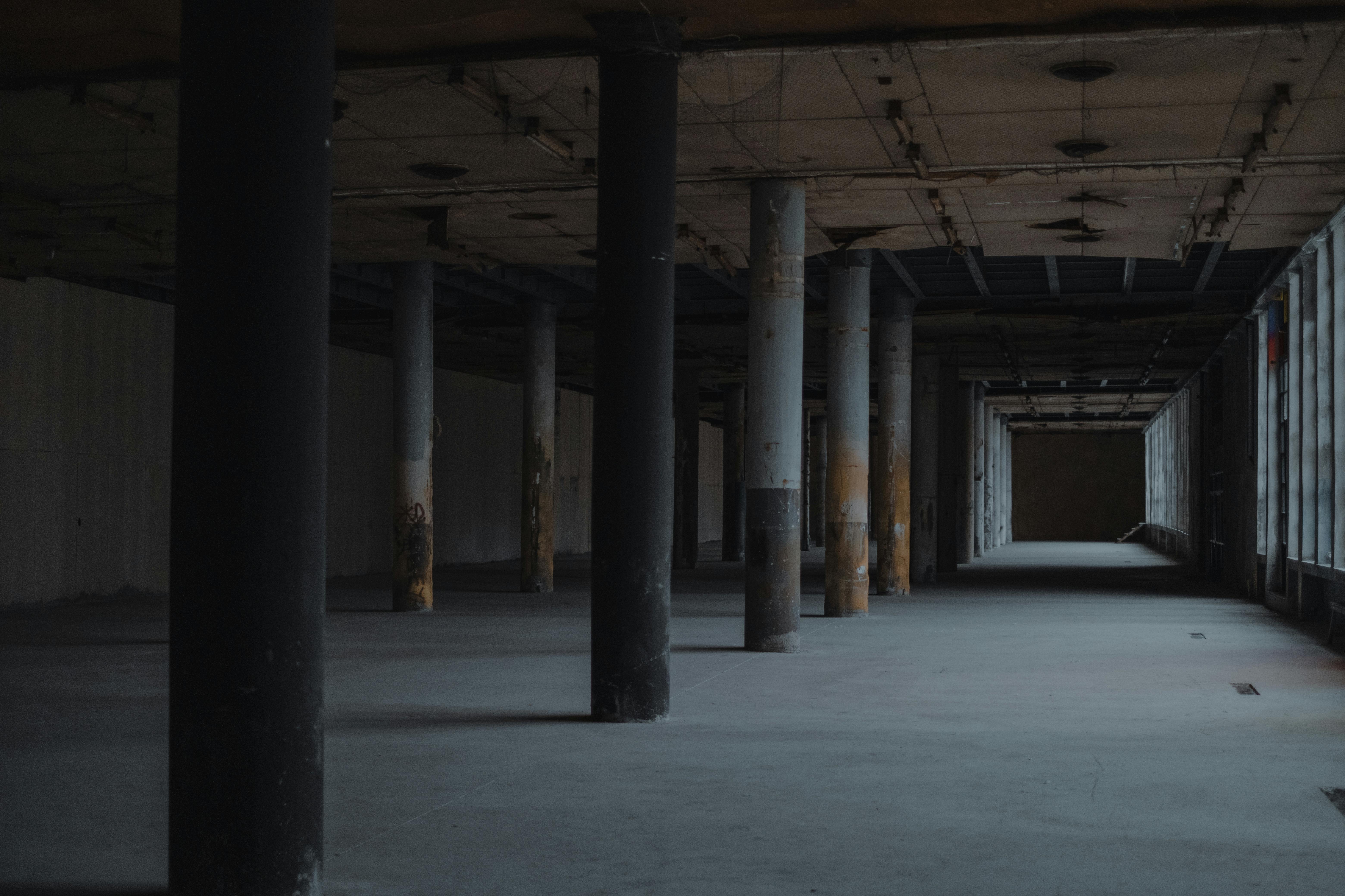 Shabby dark hall with columns and exit in far side · Free Stock Photo