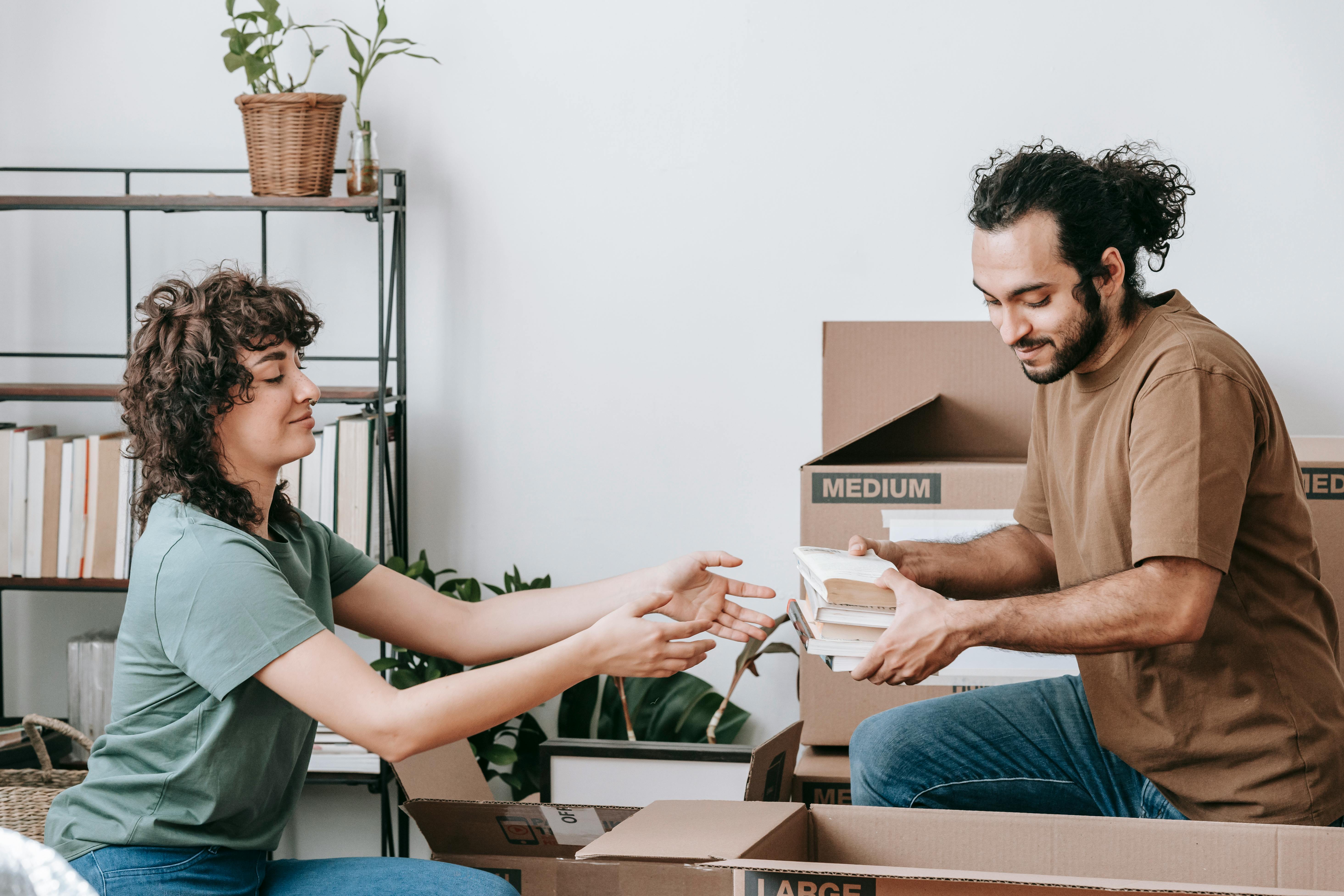 A Couple Packing Books In A Box · Free Stock Photo