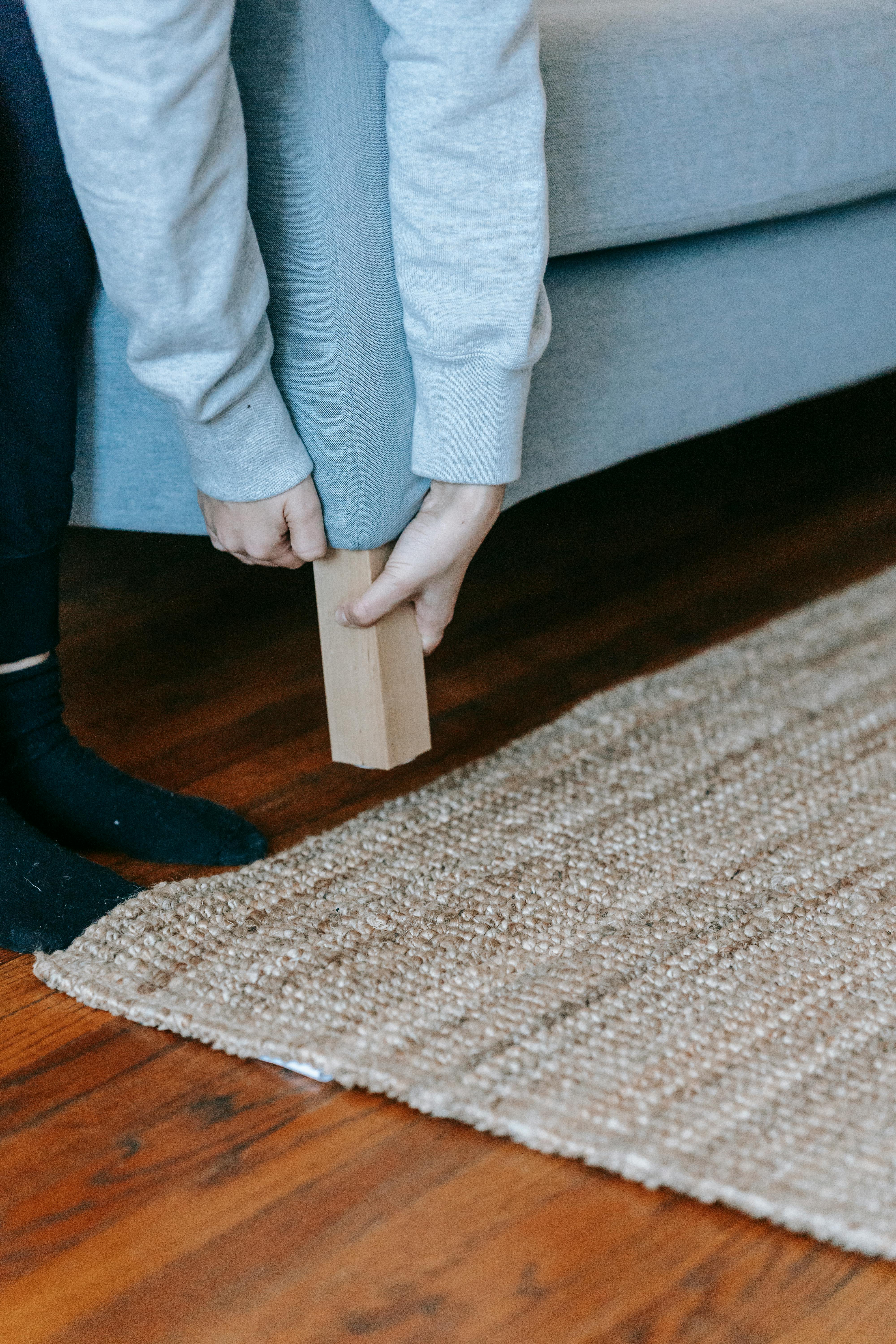 Person Lifting Up A Carpet · Free Stock Photo