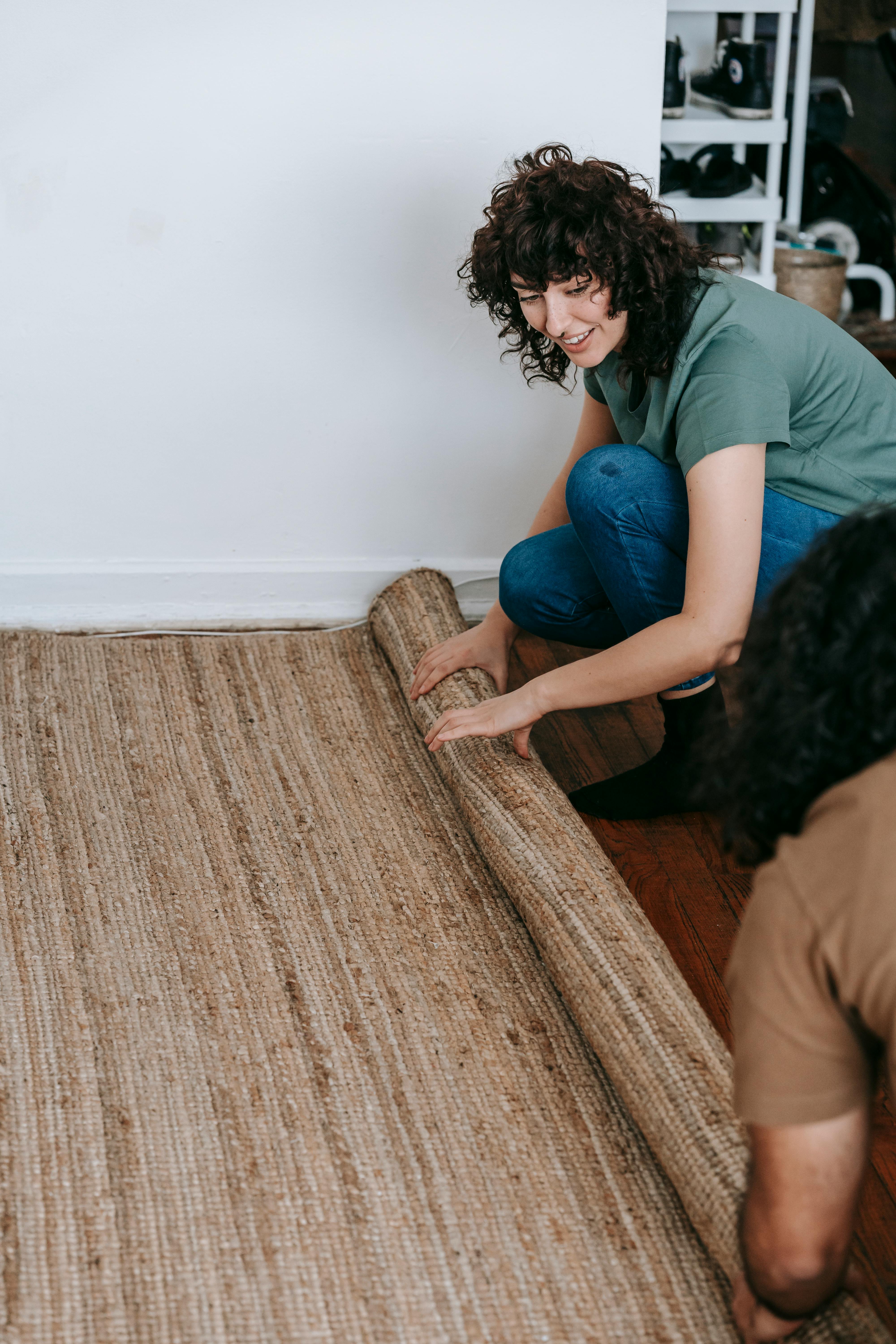 Couple Rolling Out A Carpet · Free Stock Photo