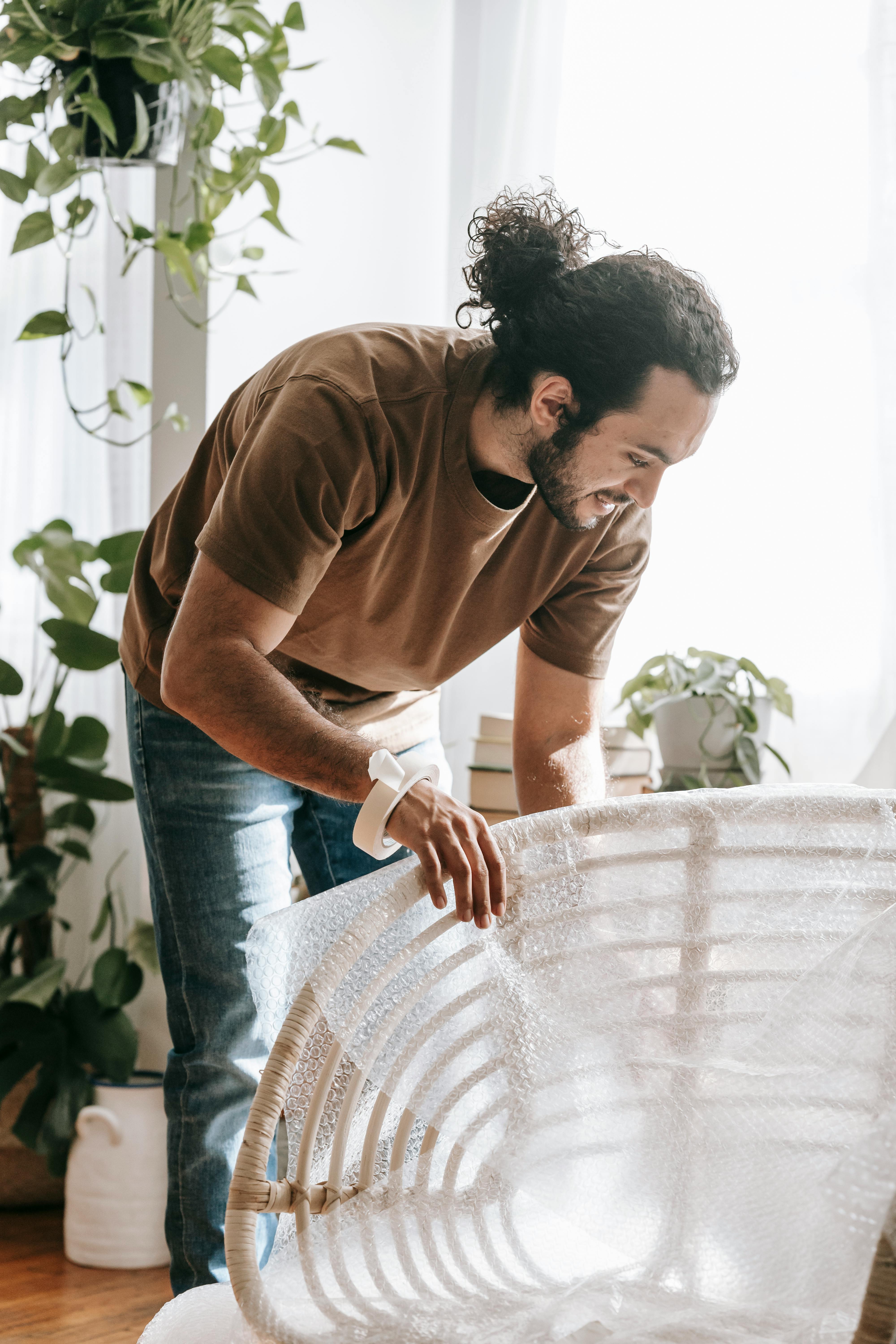Woman Wrapping A Chair With Plastic · Free Stock Photo