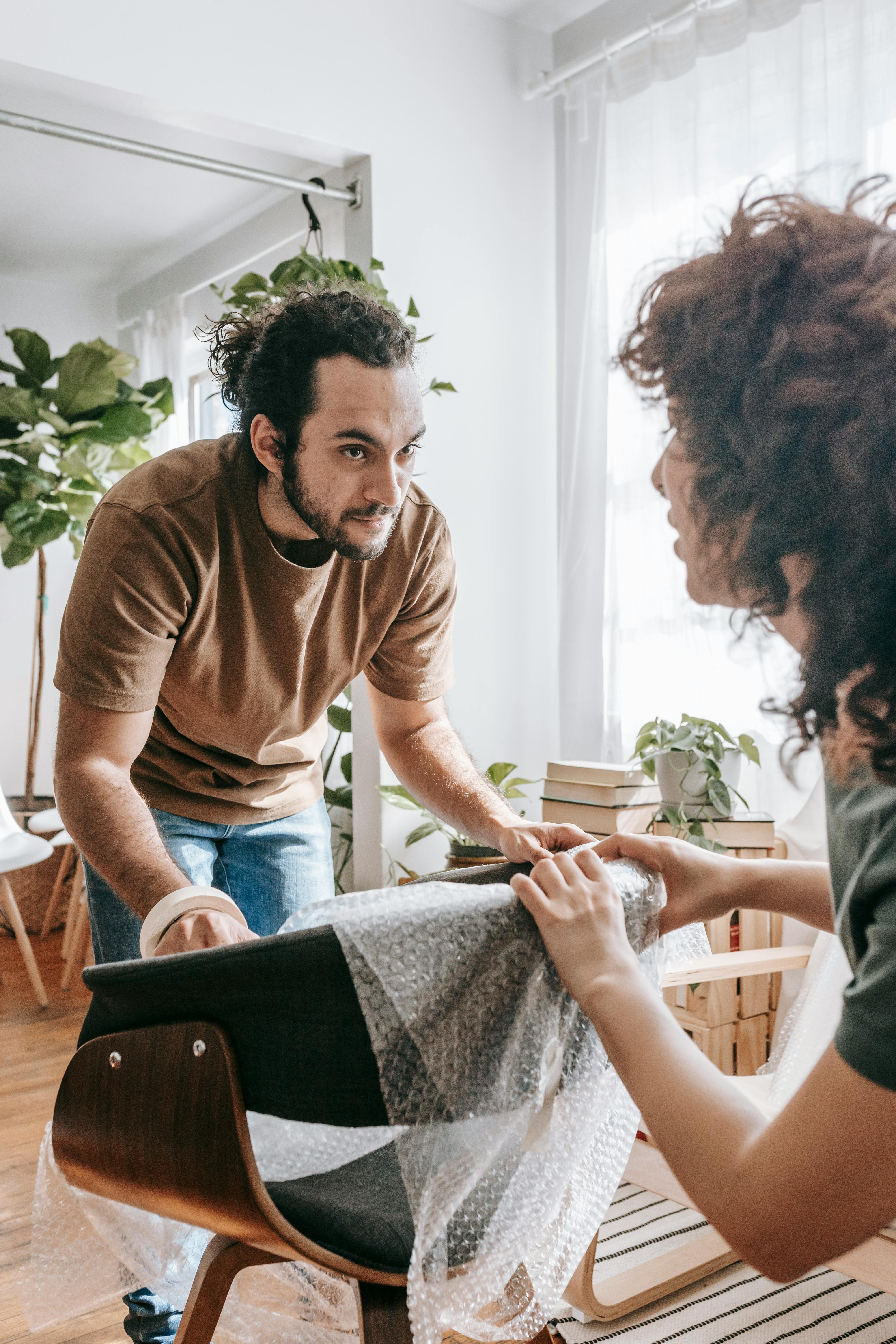 Couple Wrapping A Chair With Plastic · Free Stock Photo