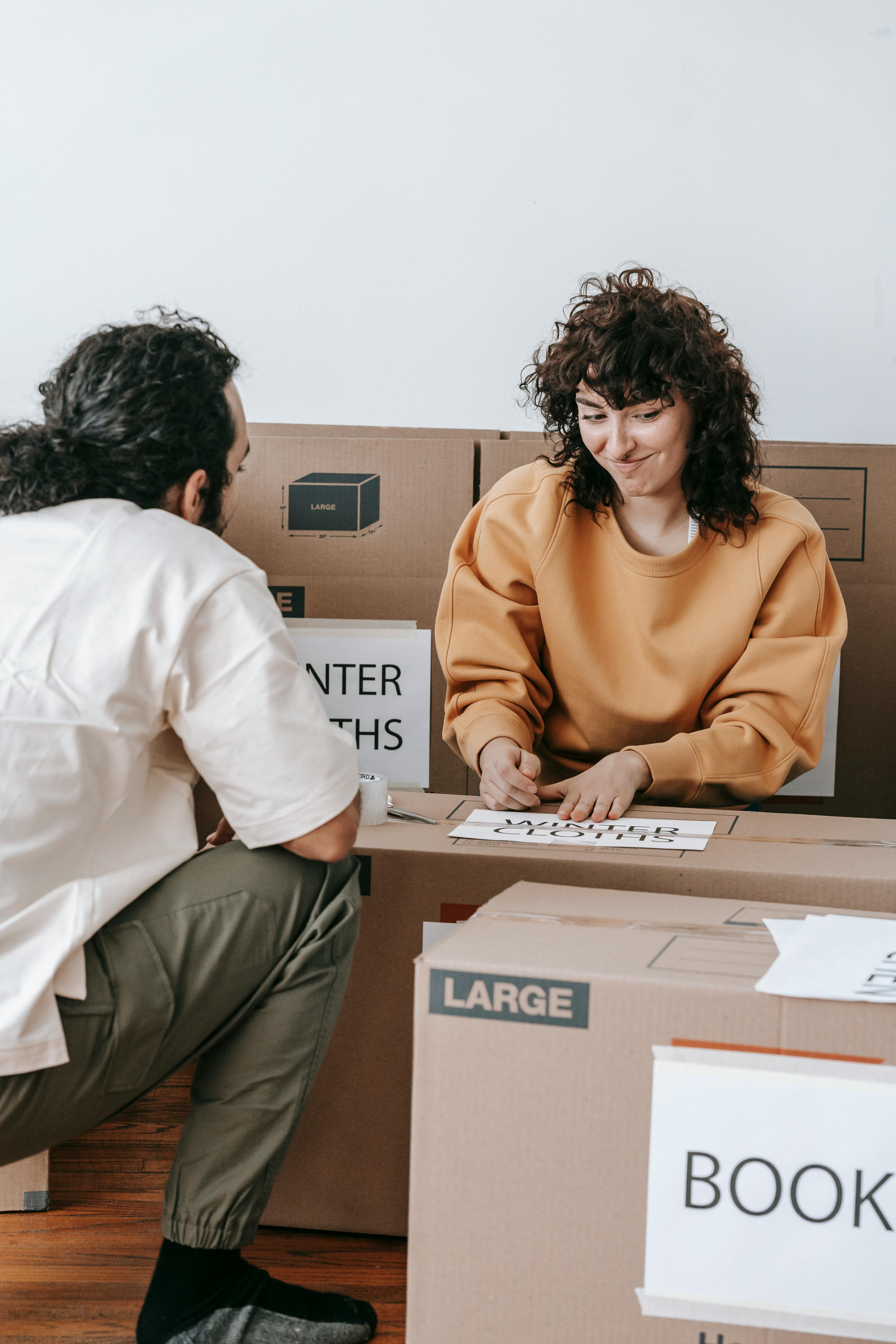 A Couple Packing Things In Boxes · Free Stock Photo
