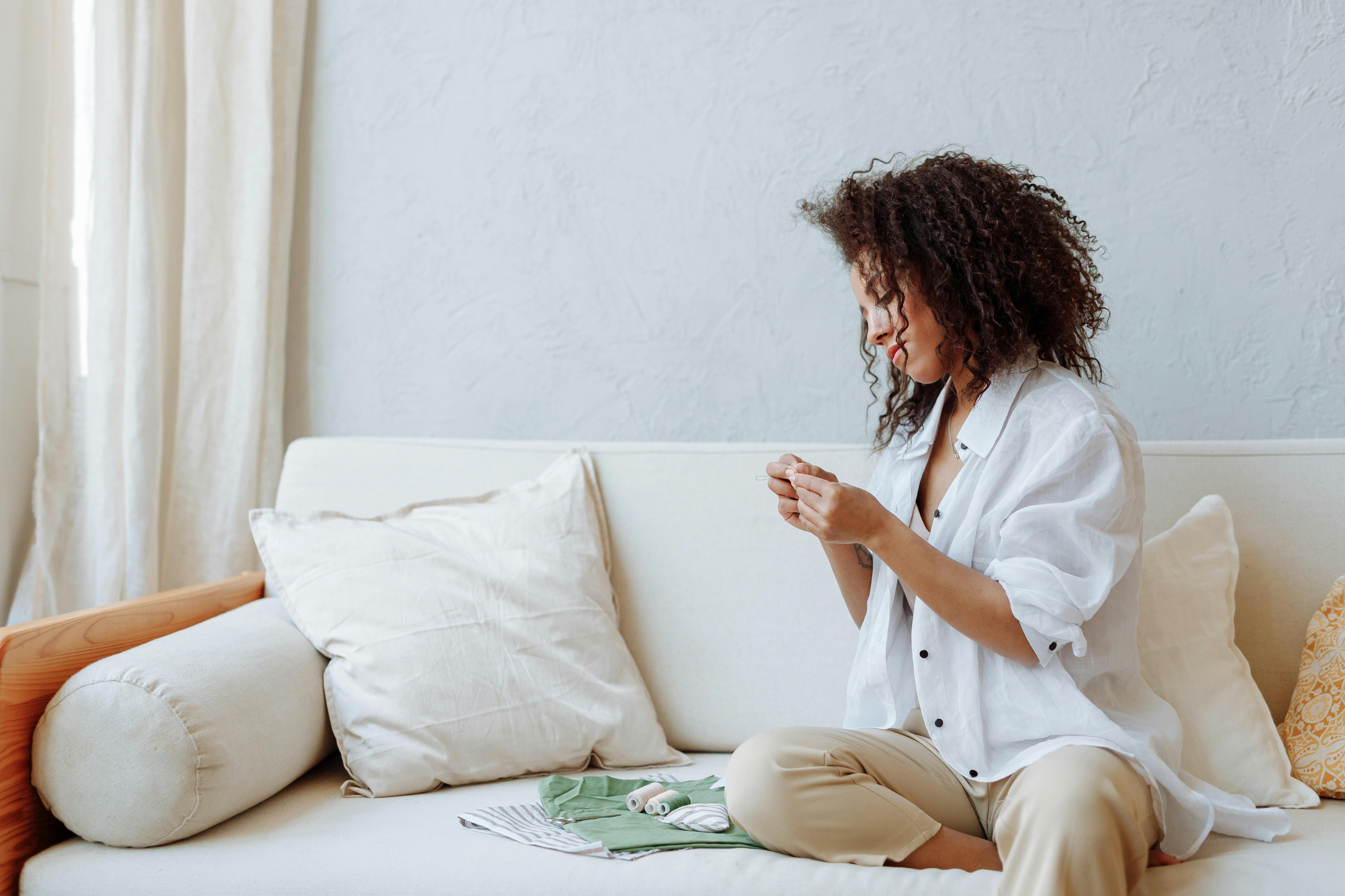 A Woman in White Long Sleeves Sitting on the Couch · Free Stock Photo