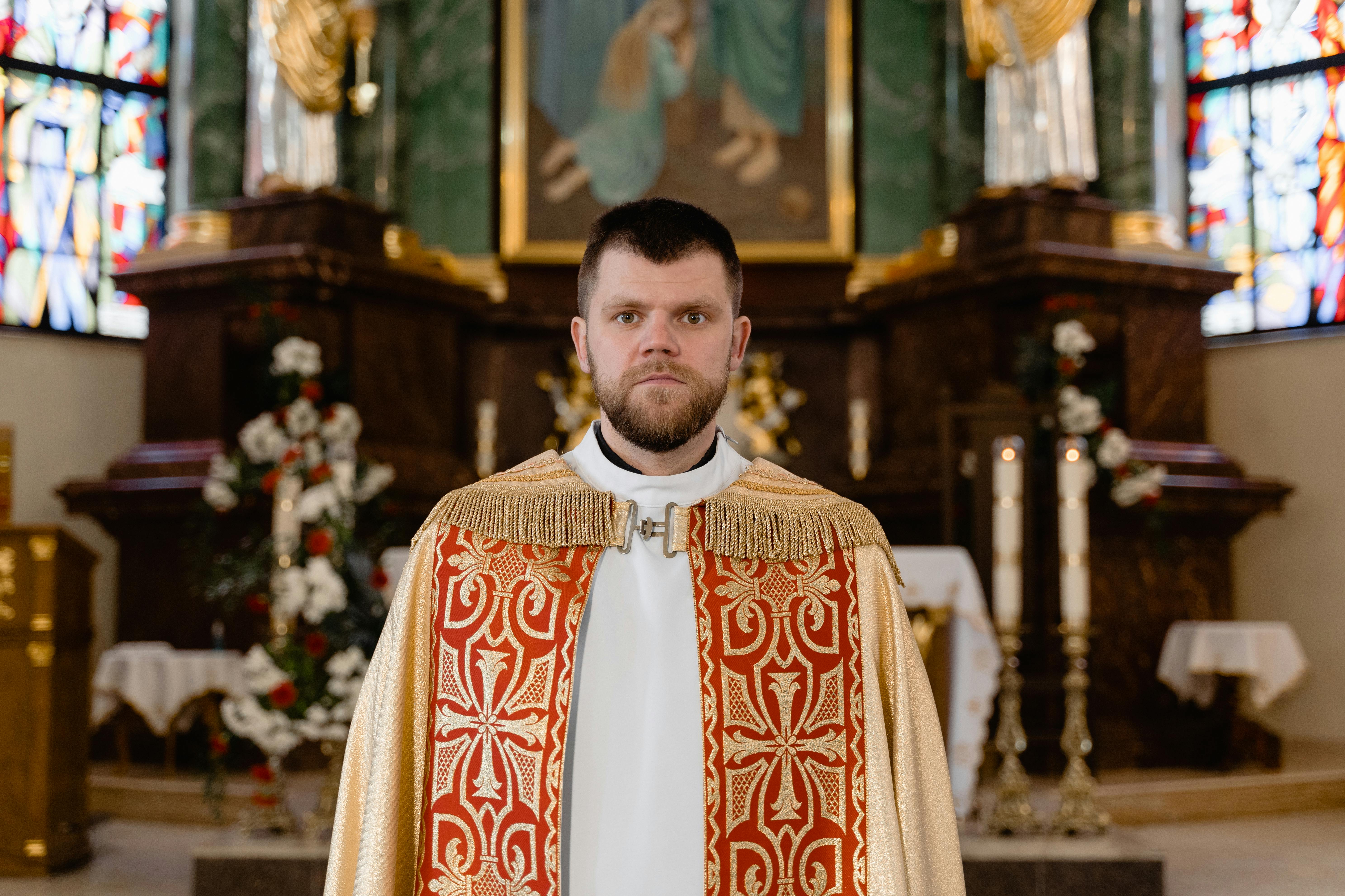 Portrait of a Priest Standing in front of an Altar · Free Stock Photo