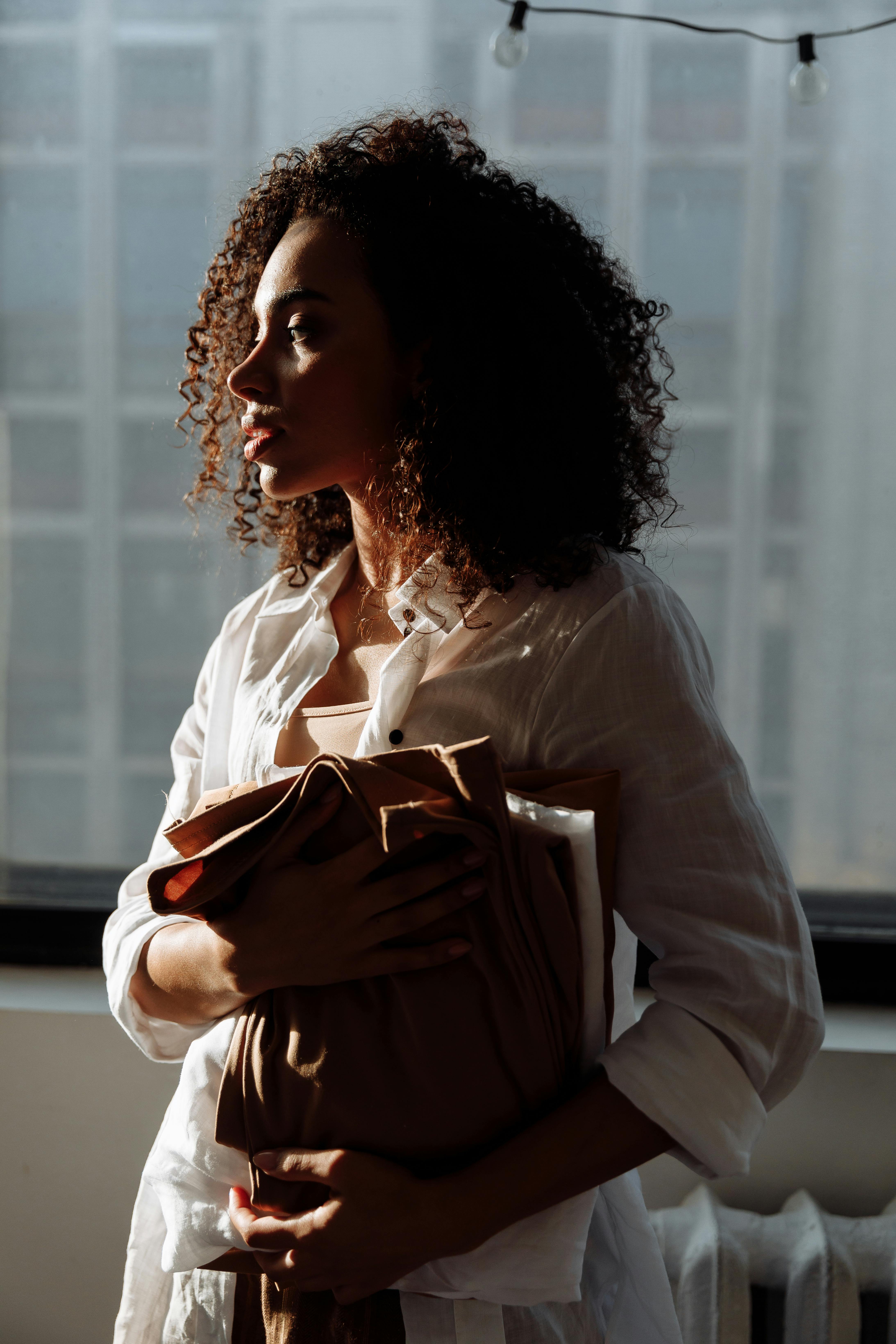 Woman Holding Folded Clothes · Free Stock Photo