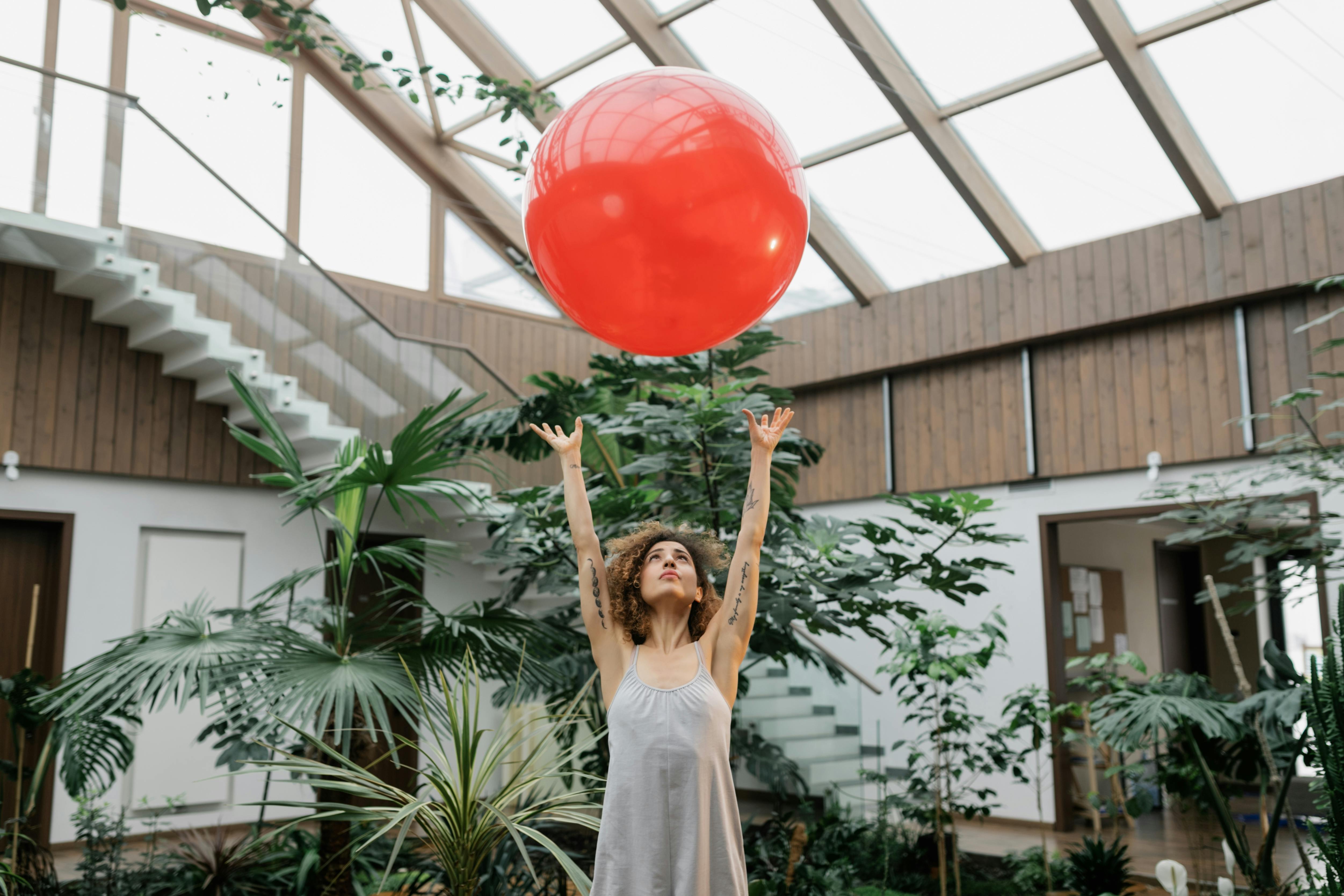 Woman Tossing a Red Ball · Free Stock Photo