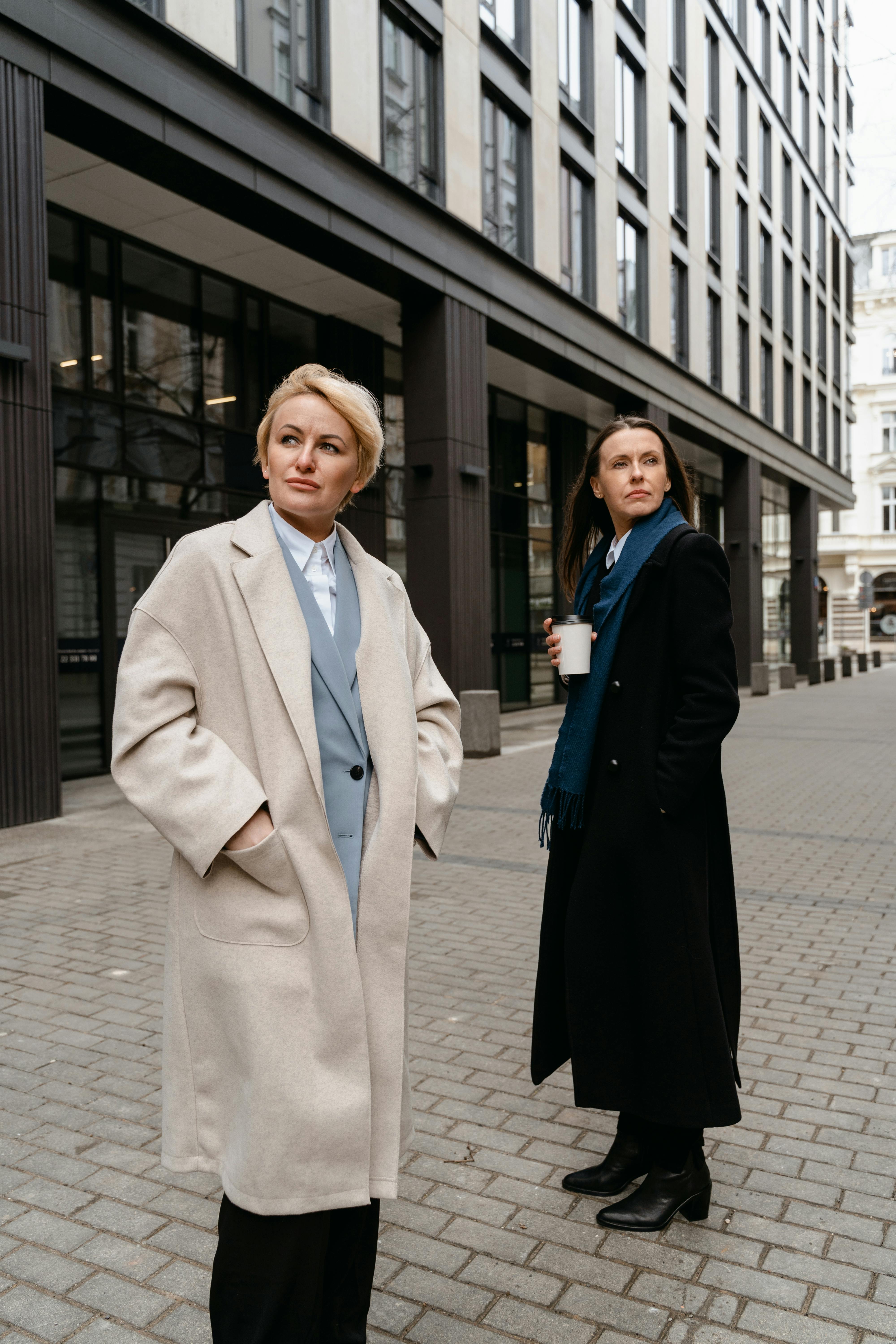 Two Women Wearing Coats Posing in the Street · Free Stock Photo