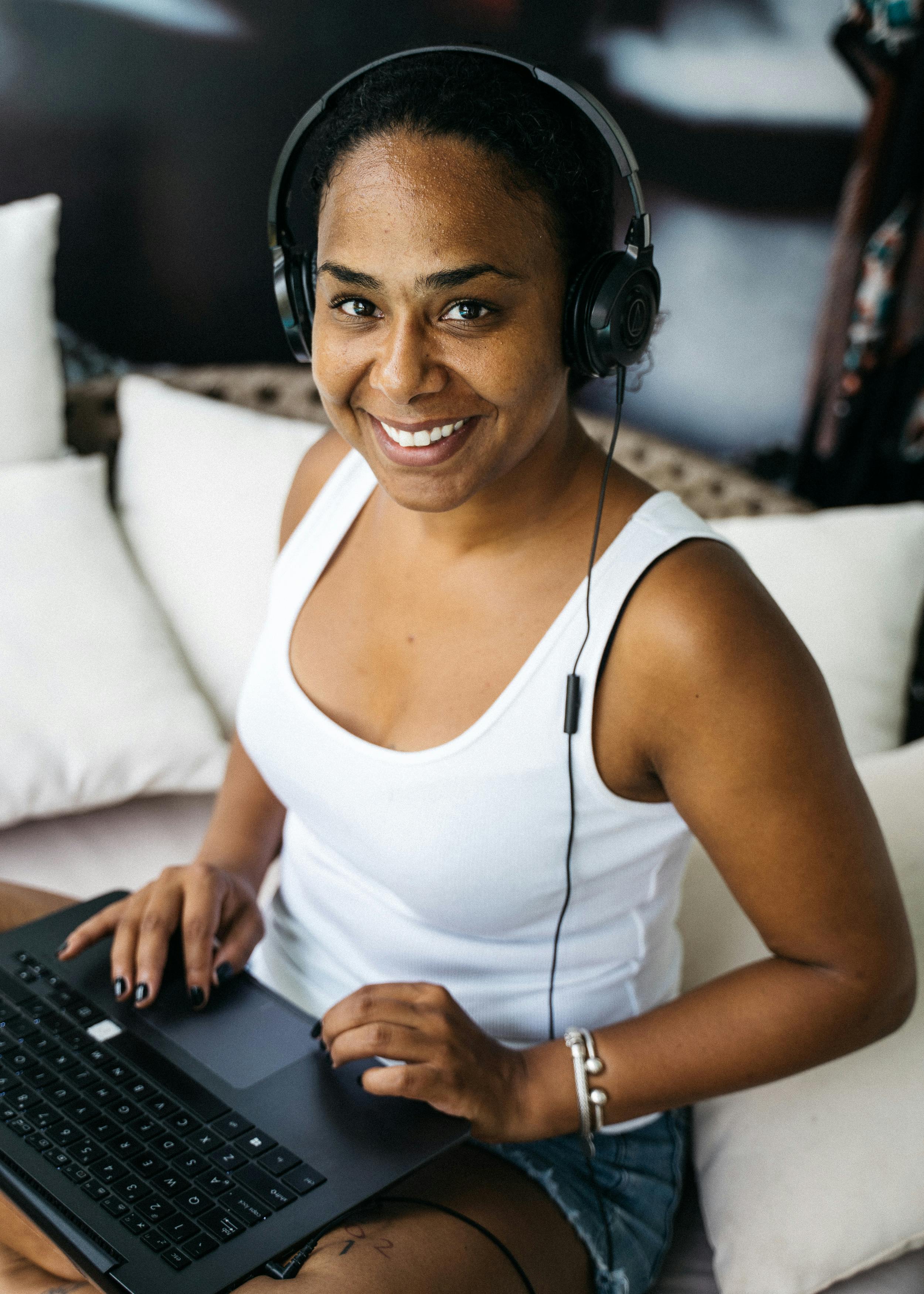 A Pretty Woman in Black Tank Top Using a Laptop · Free Stock Photo