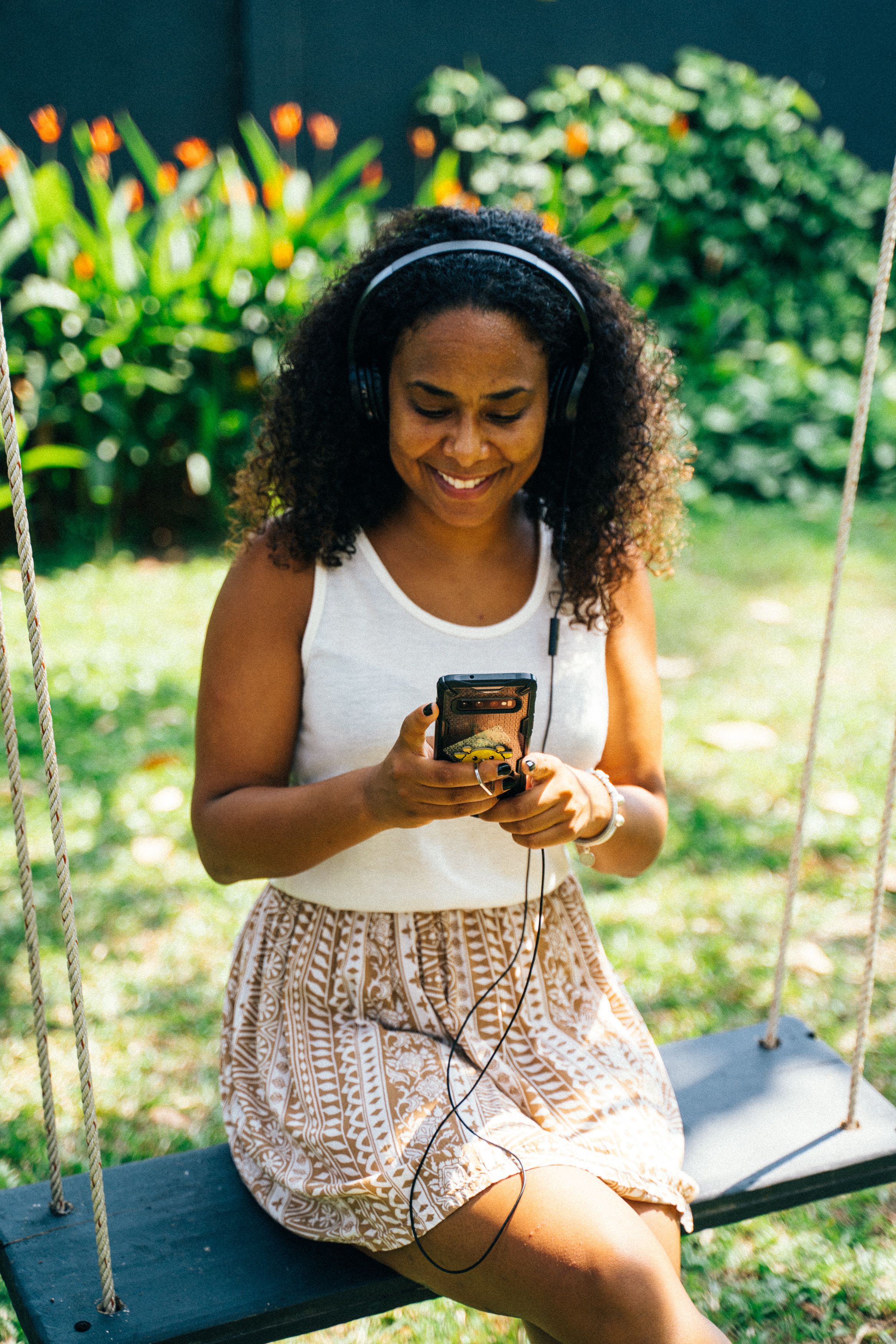 Woman Sitting on Swing While Holding a Mobile Phone · Free Stock Photo